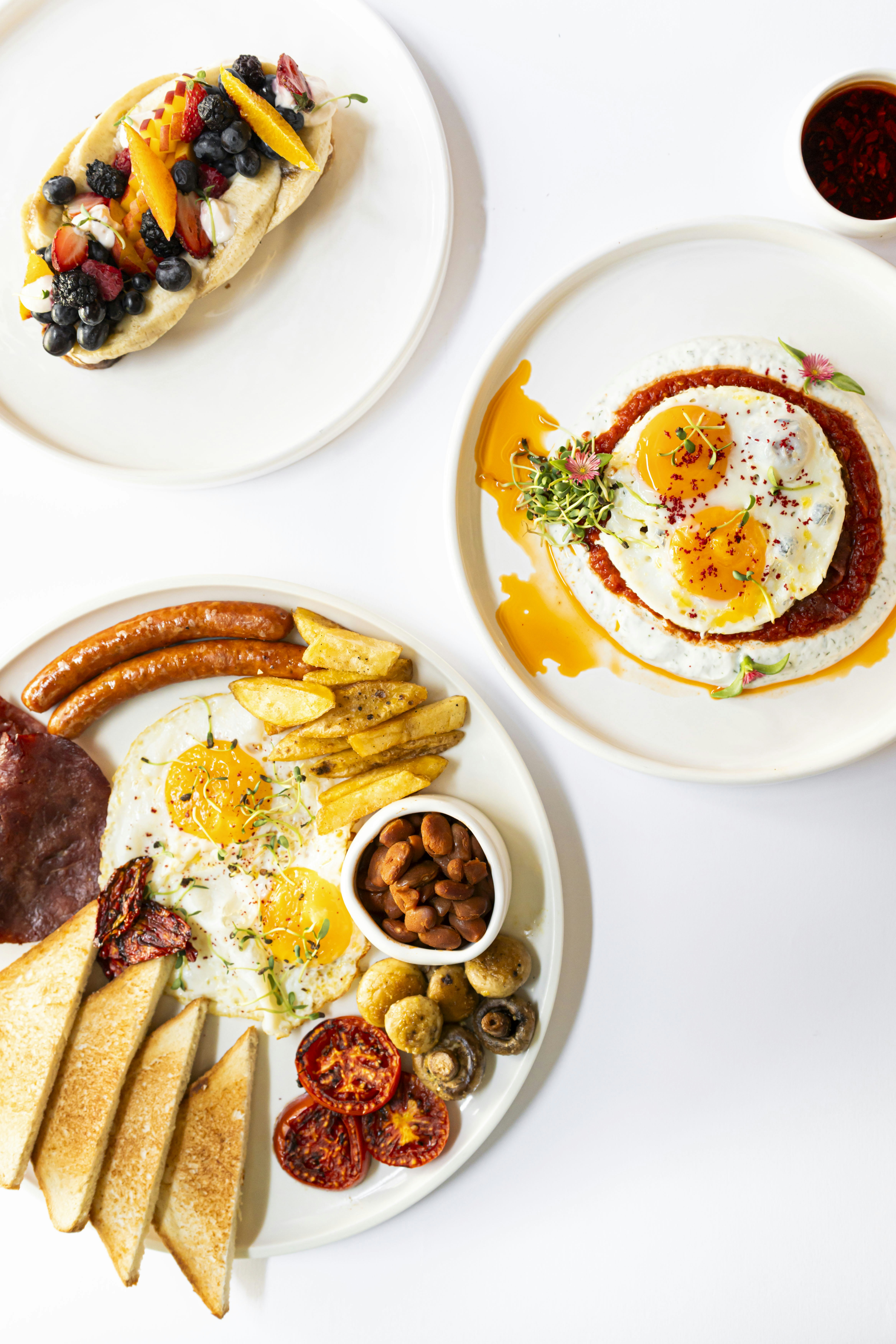 Three Plates of Brunch Art: Eggs, Toasts, and Fresh Berries