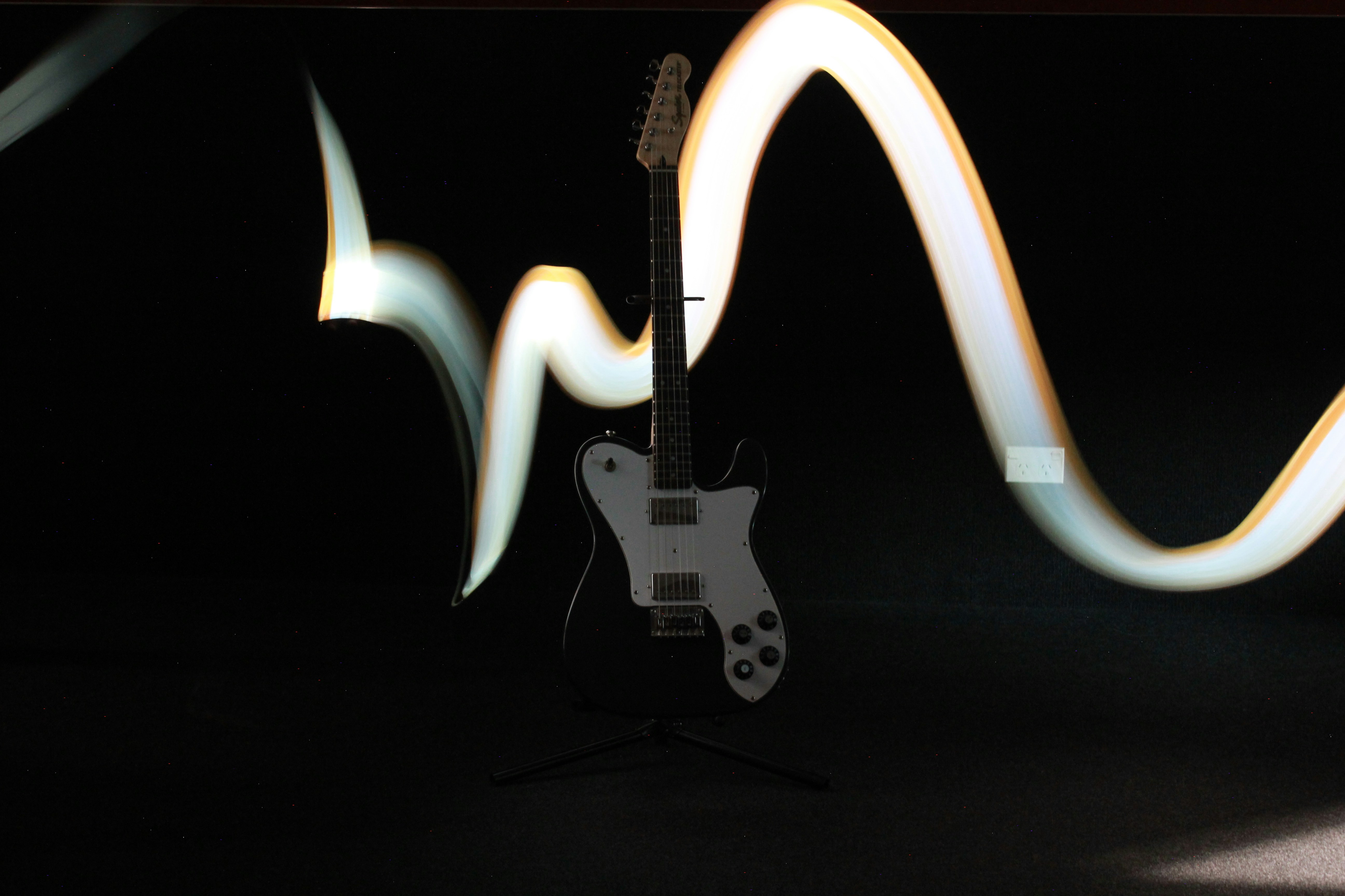Midnight riff: a lone electric guitar under flowing light trails