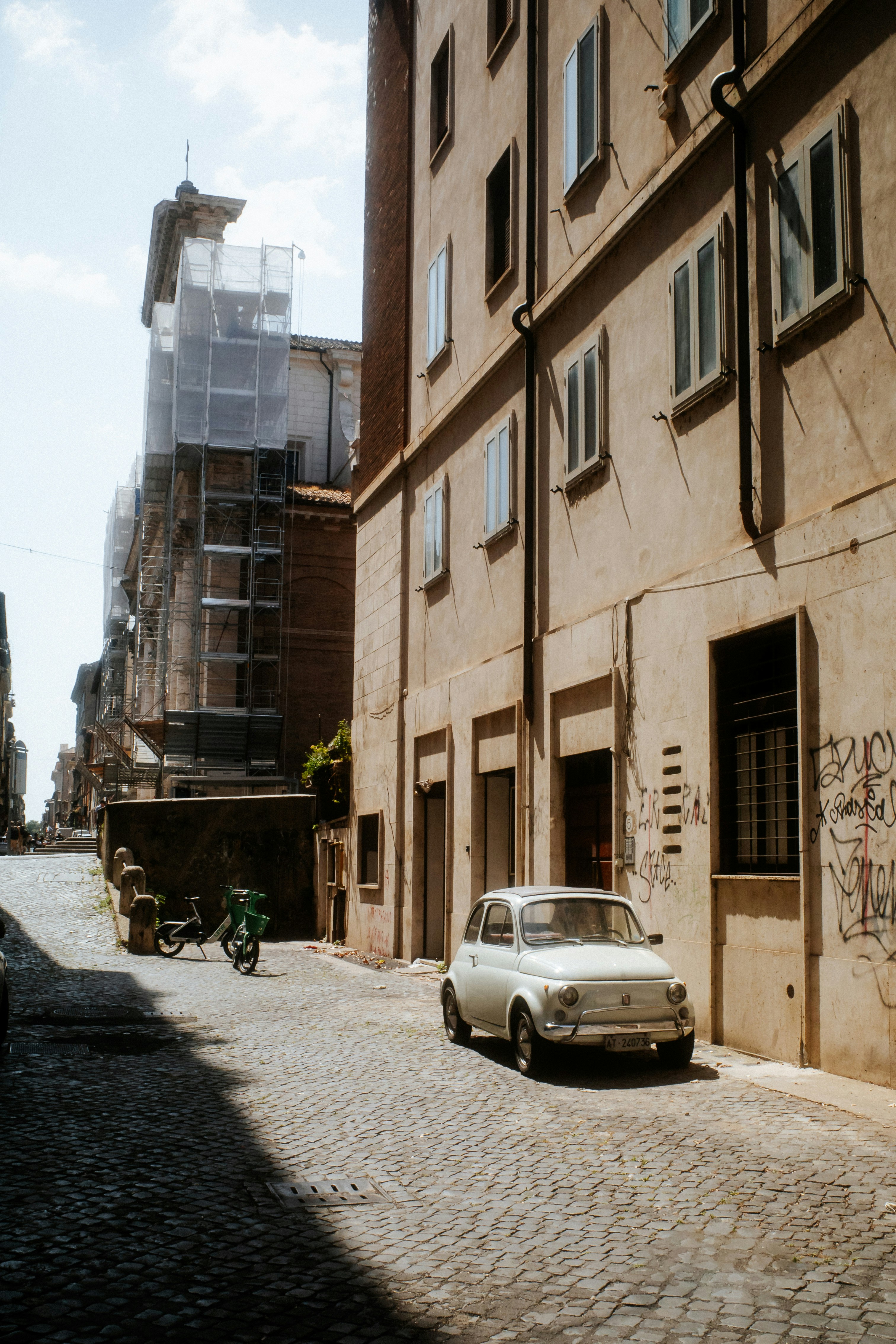 Sunlit Street Car: A Quiet Italian Alley with a Vintage Fiat