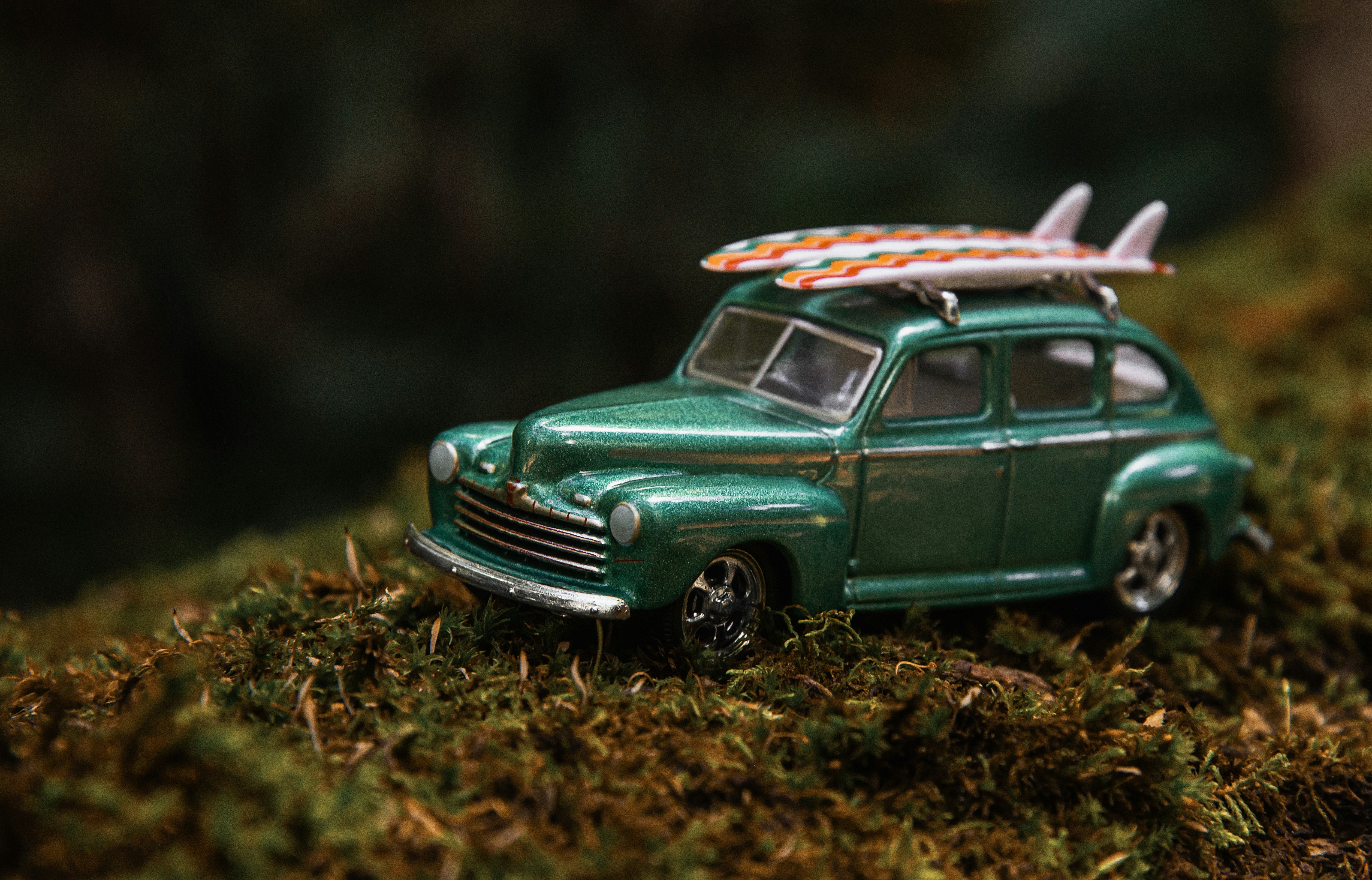 Mini Surf Rig on Moss: A Green Vintage Car Zooming Through Nature