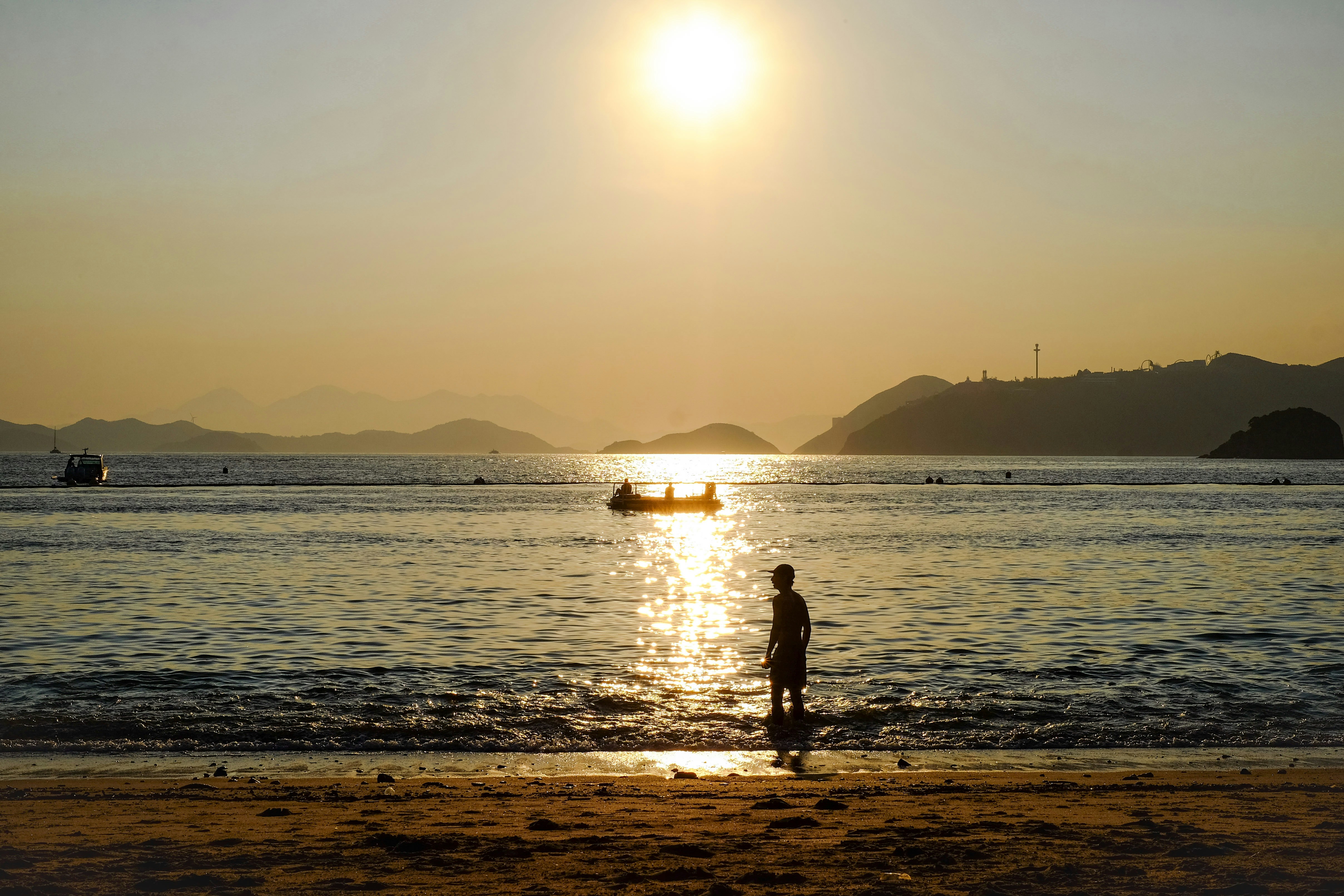 Sunlit silhouette: solitary swimmer at the waterline