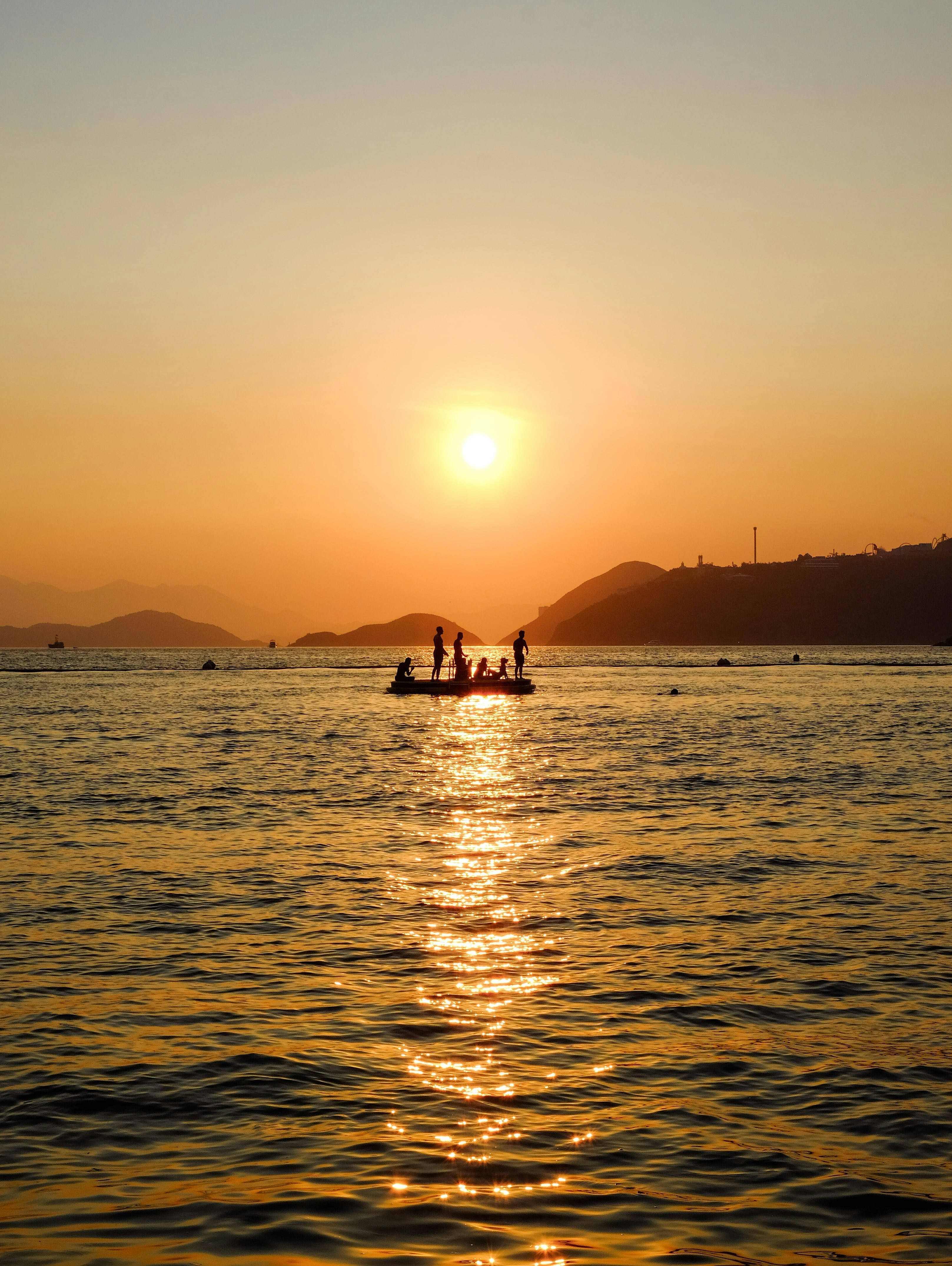 Sunlit Boat Silhouette Amid a Golden Ocean Dusk