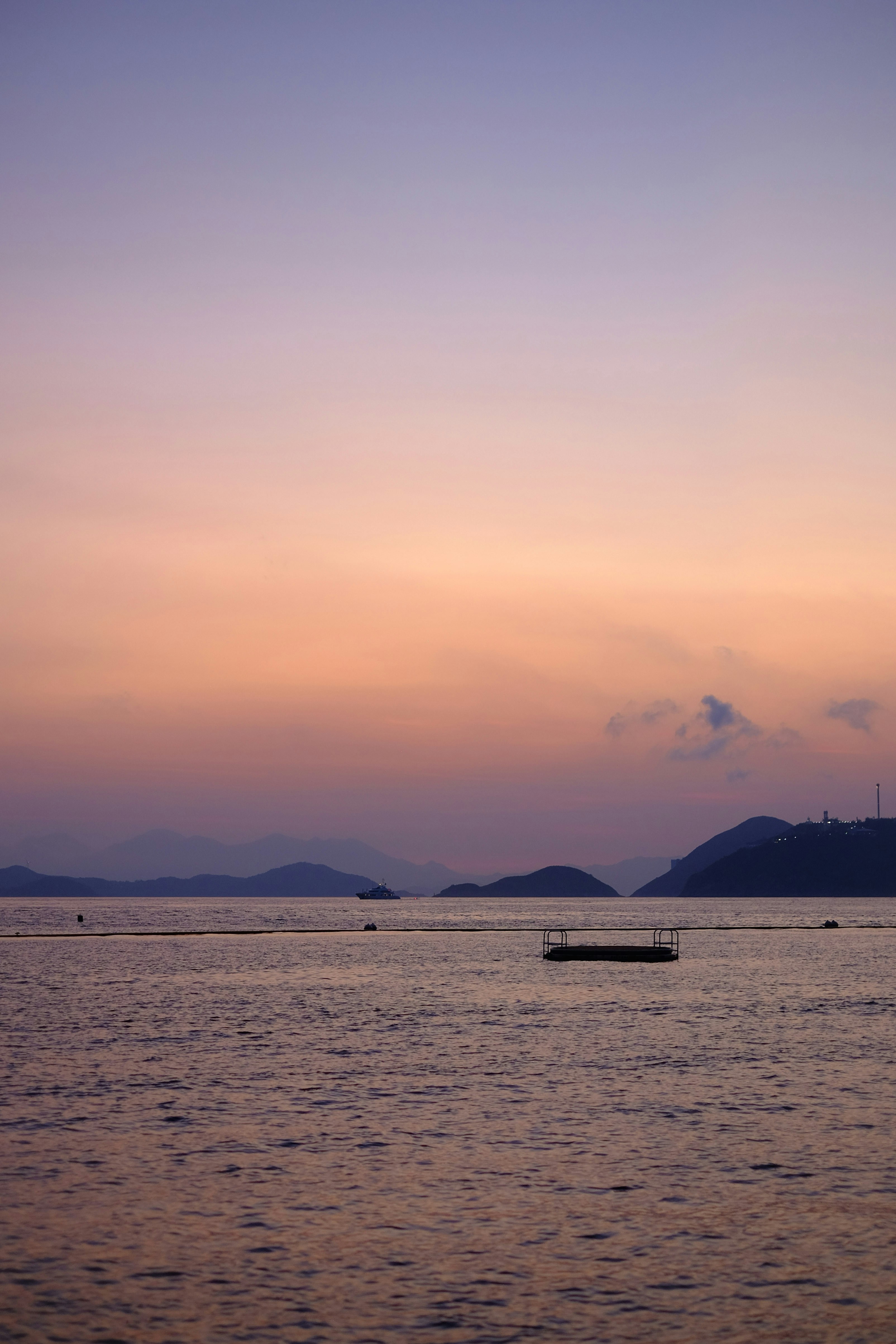 Sunset Over Quiet Waters: A Rim of Islands and a Floating Pier