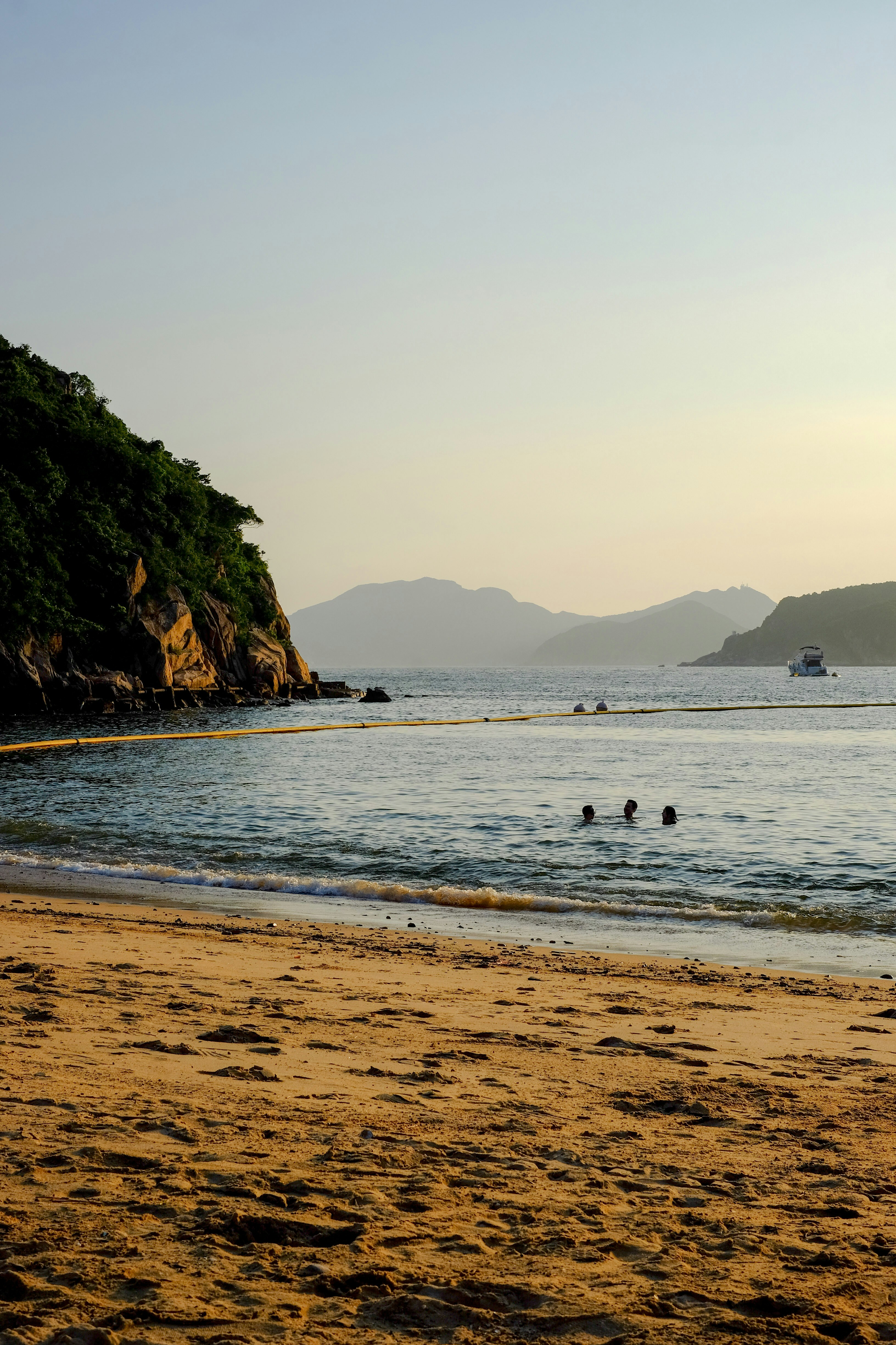 Sunlit Shoreline: People and Boat Amid Quiet Seas