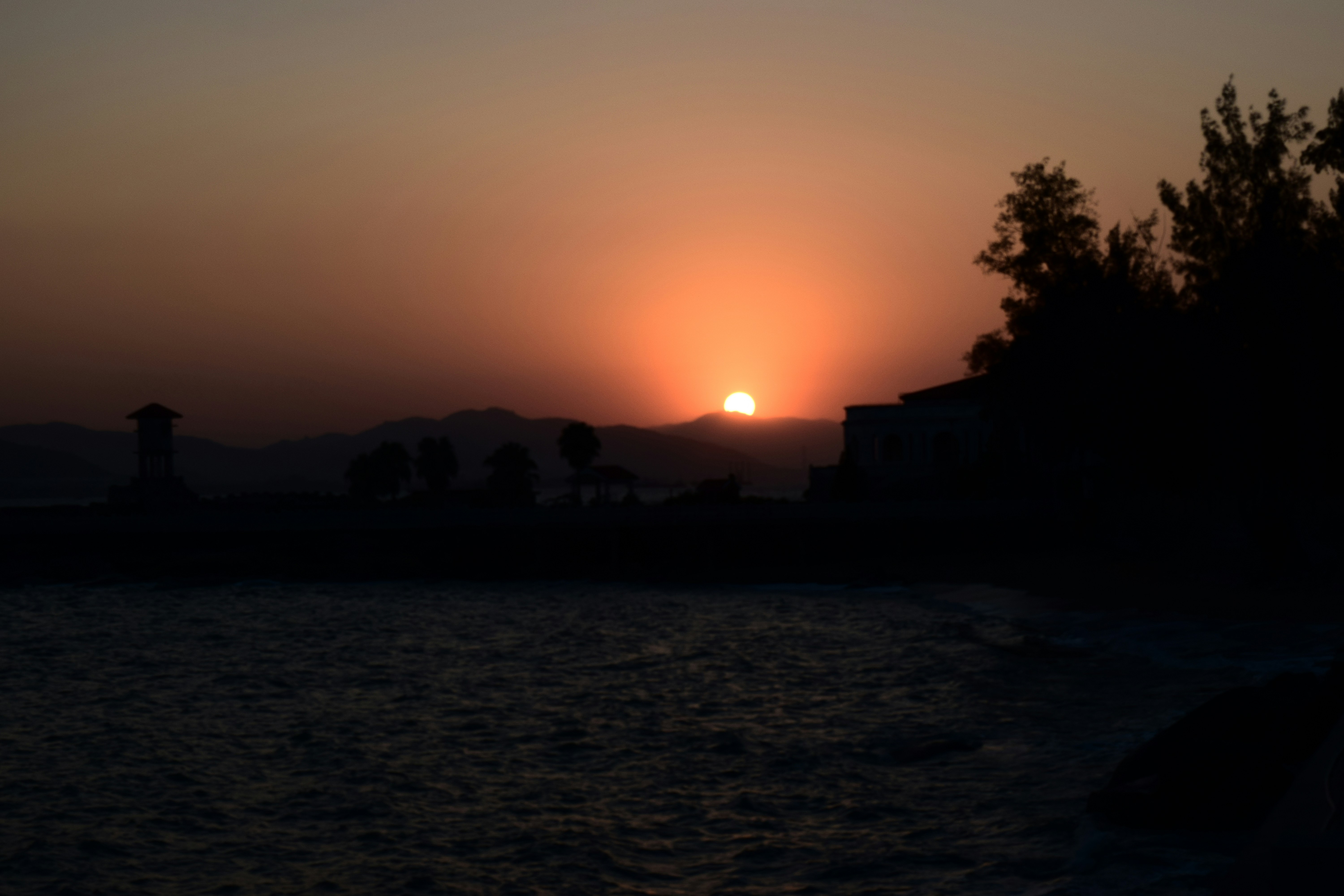Sunset Silhouette Over Calm Shore