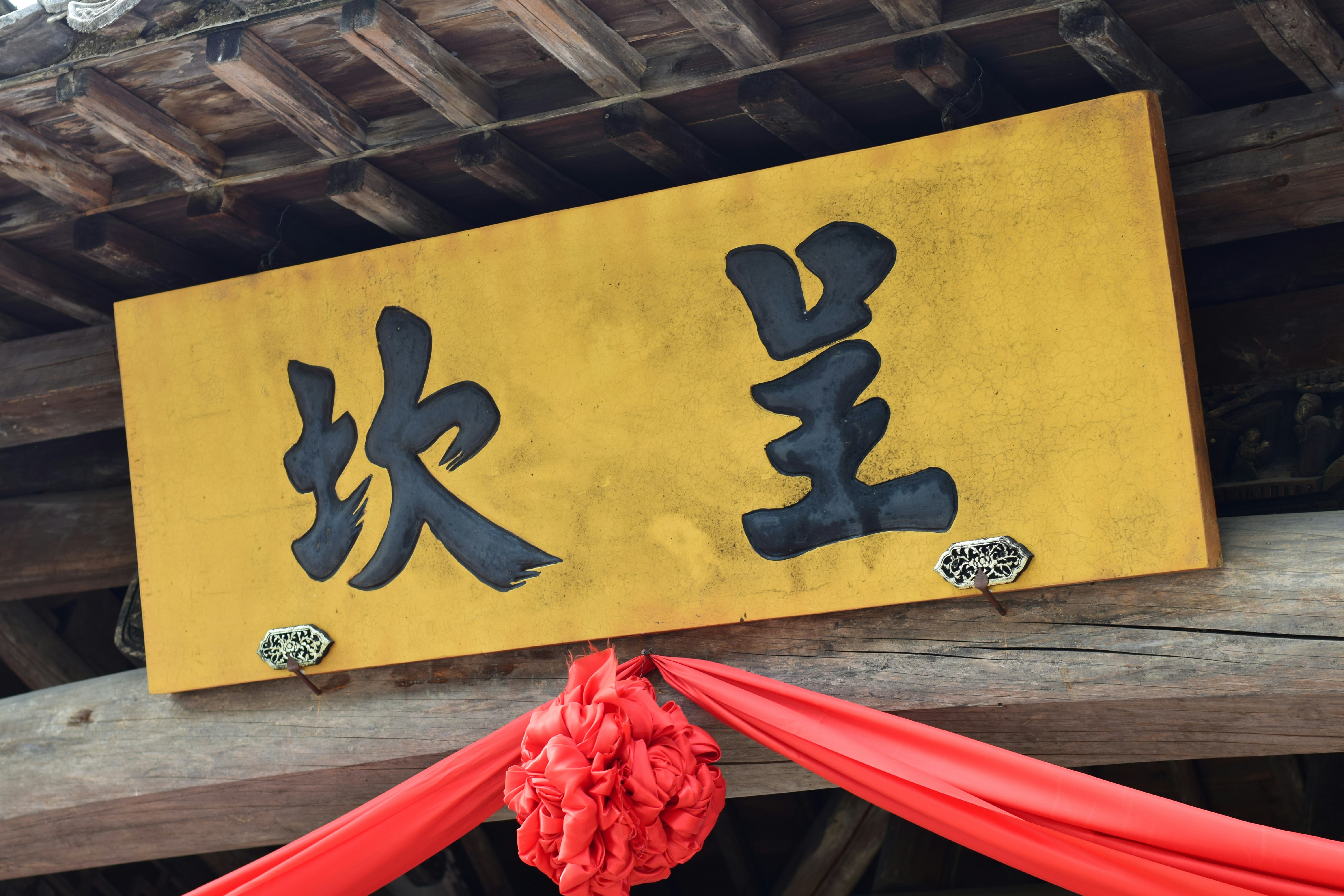 Golden Signboard with Bold Chinese Characters and Festive Red Ribbon