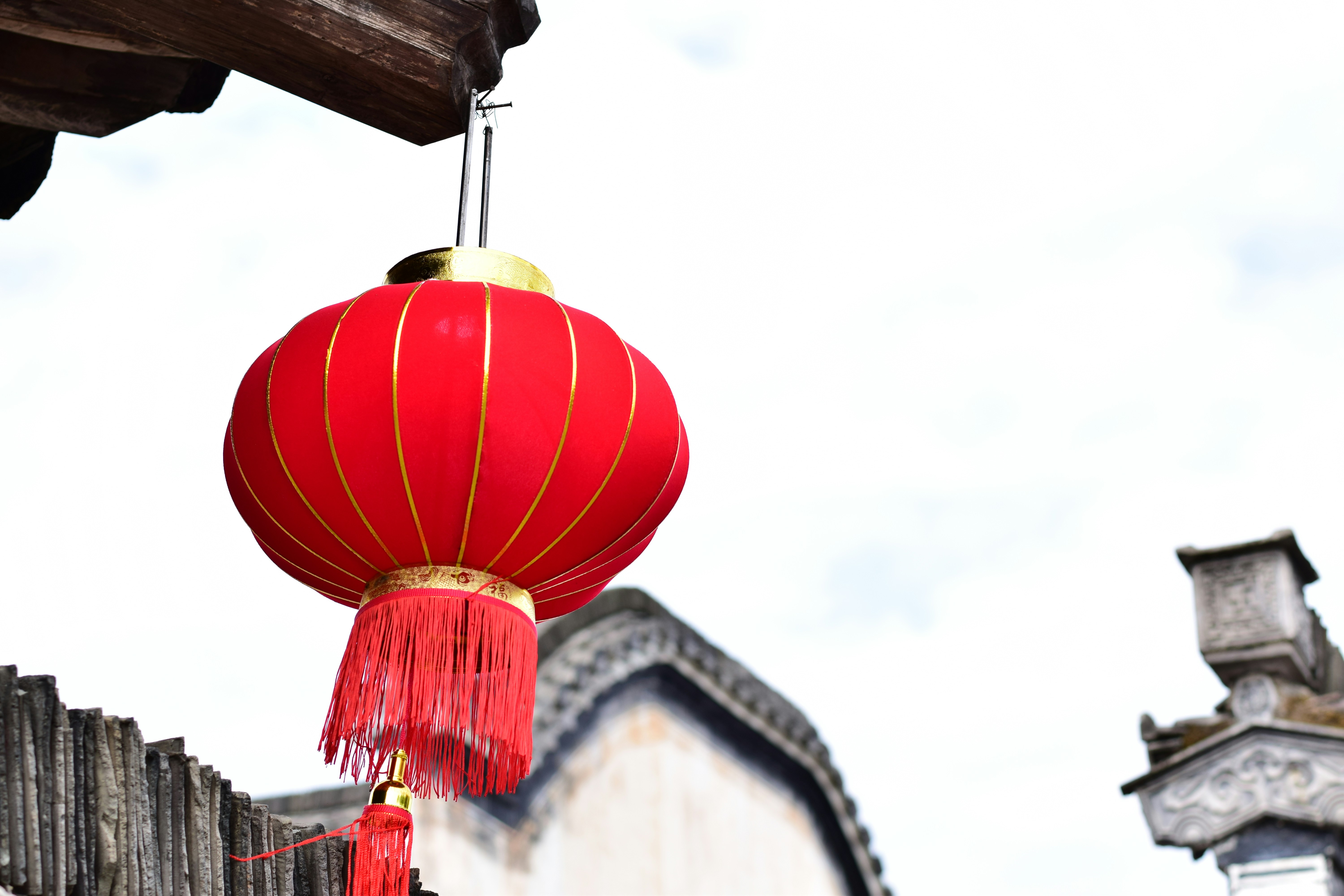 Red Lantern Glow Against Aged Rooflines
