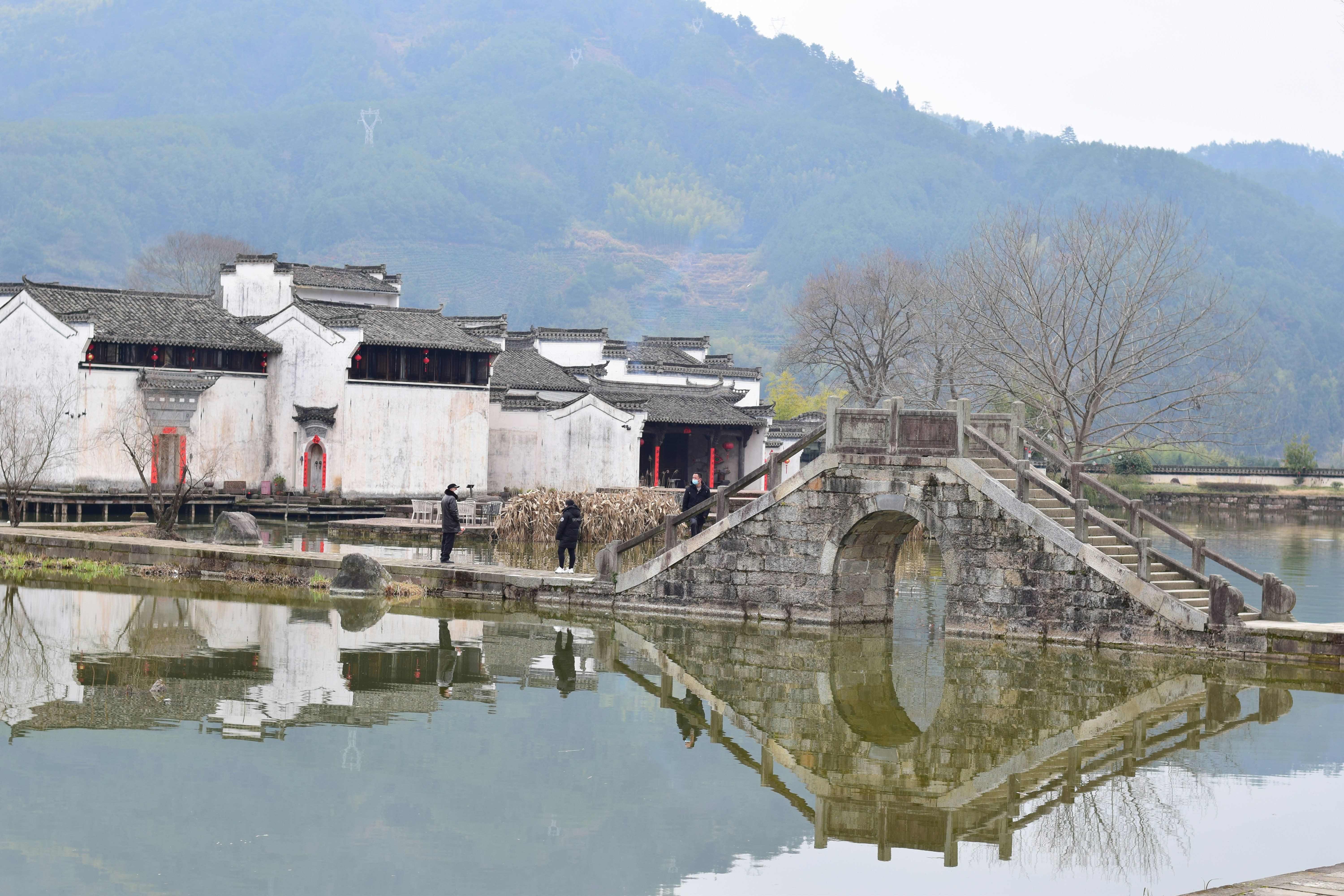 Heritage Bridge Over Calm Water with Riverside Row and Misty Hills