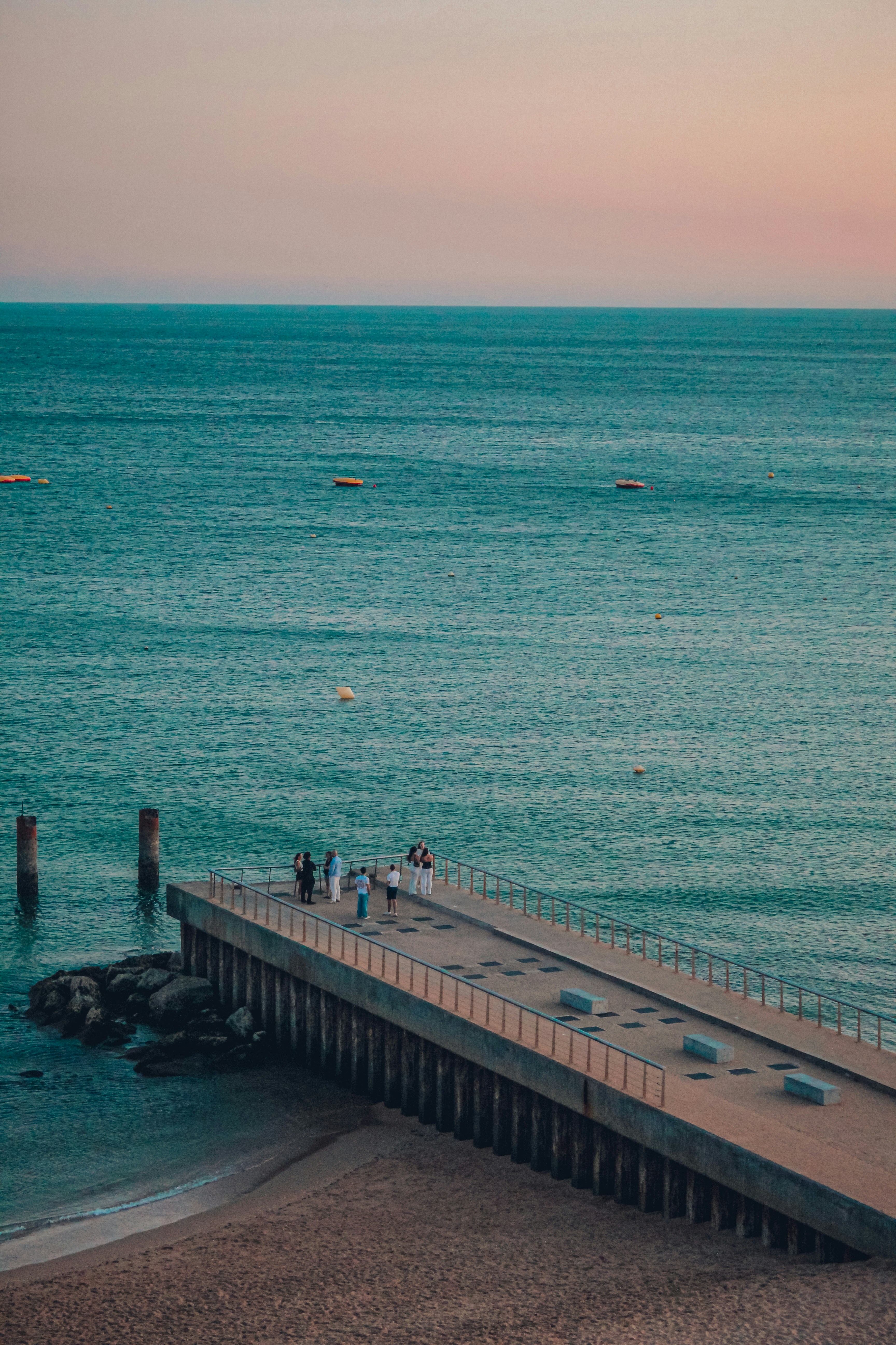 Pier at Dusk: People Gathering at the Sea Edge