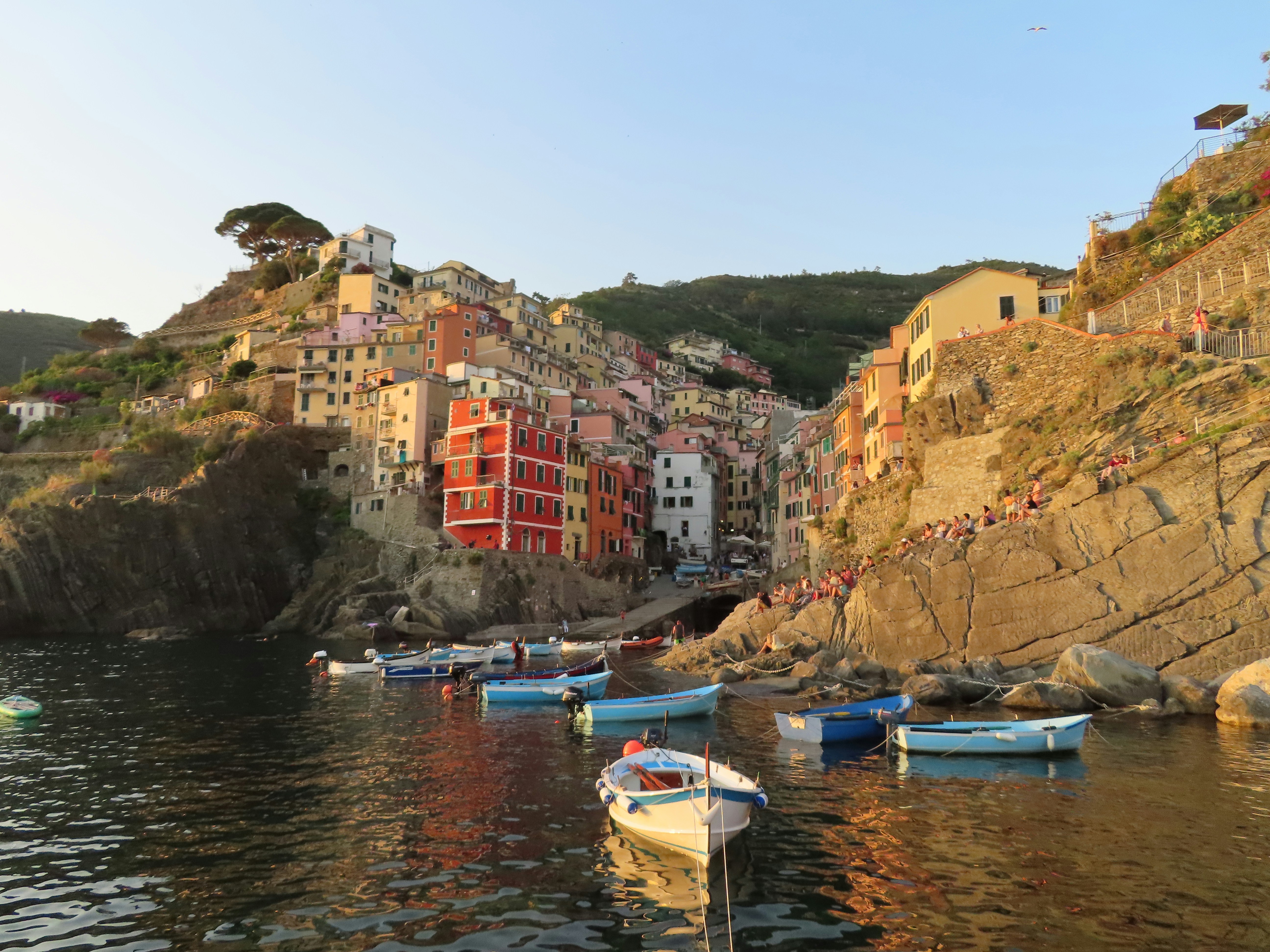 Colorful hillside village greeting the sea at golden hour