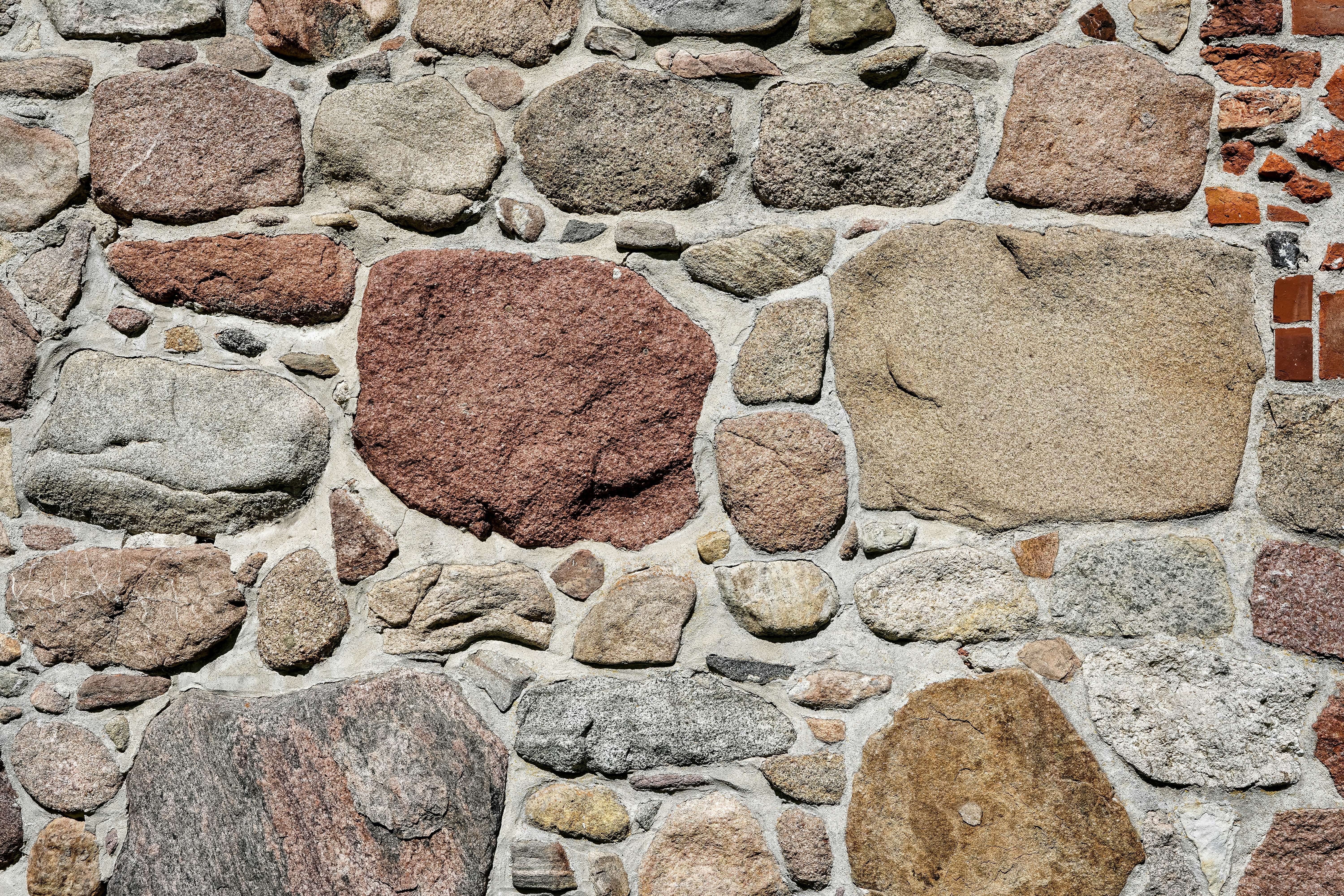 Rugged Stone Mosaic: A Sunlit Wall of Pebbled Quiet