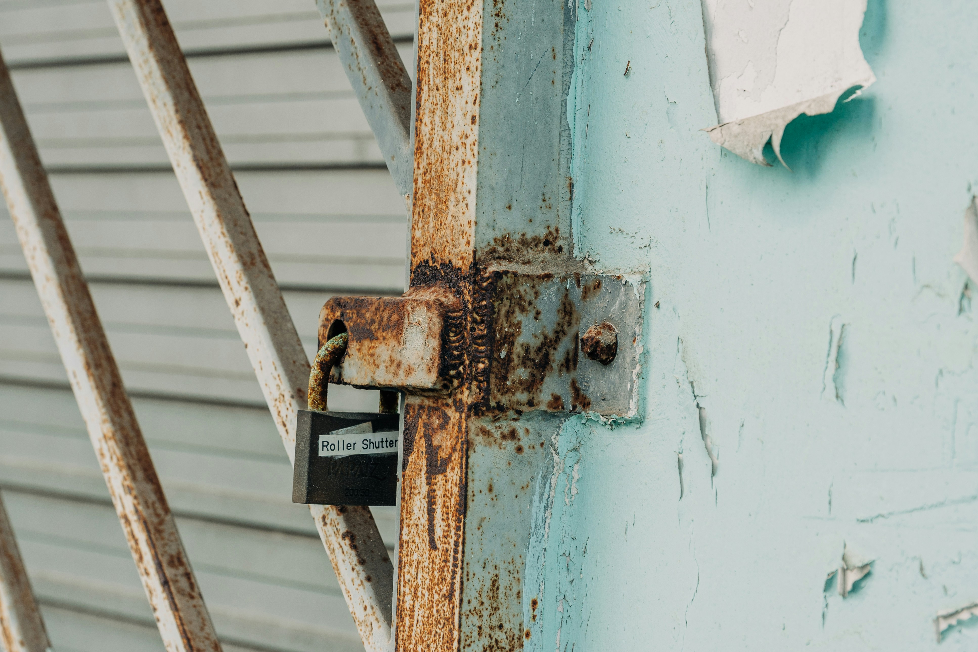 Rust and Teal: A Close-Up on a Weathered Gate Latch