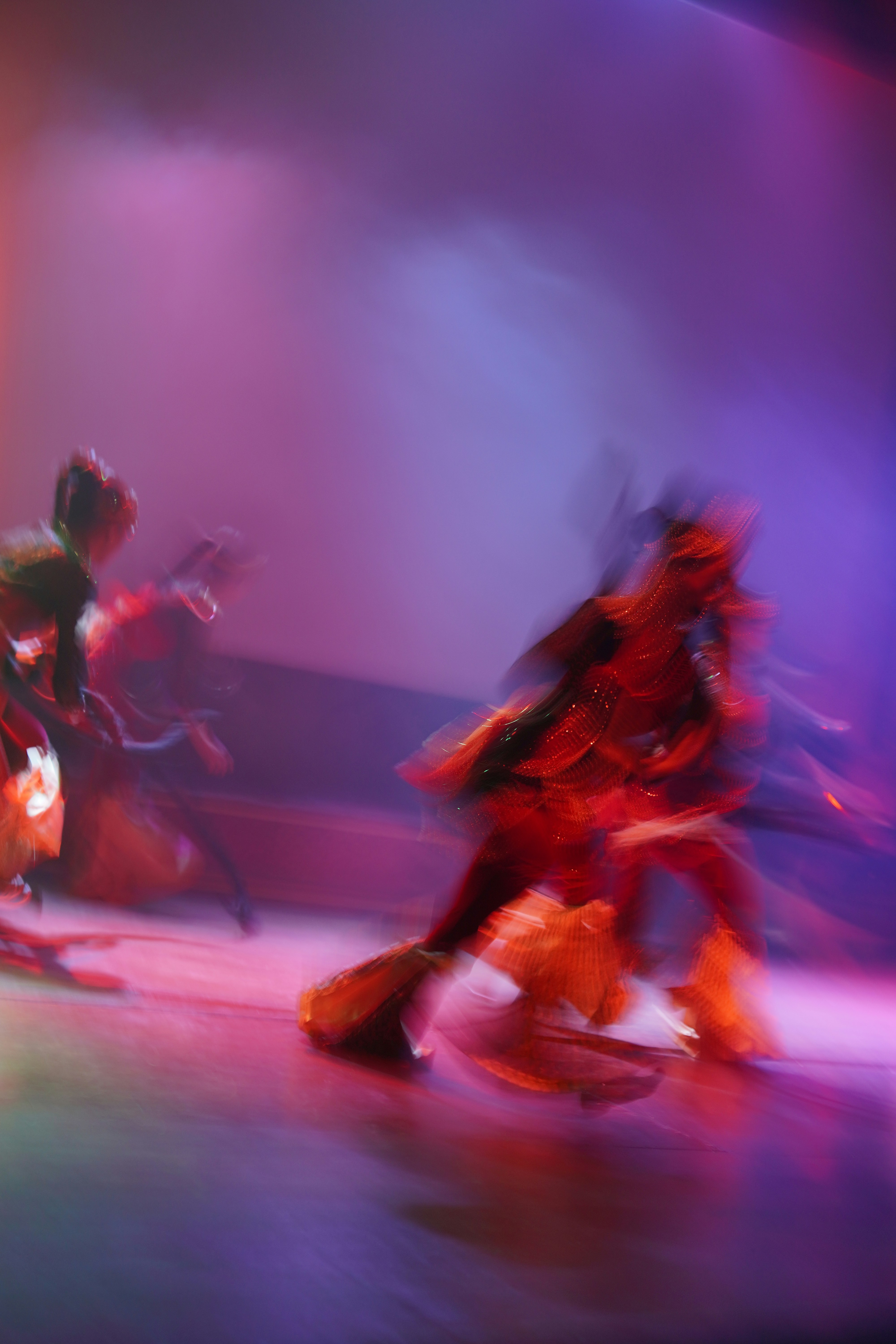 Midnight Dance: Blurred Figures Under Neon Haze