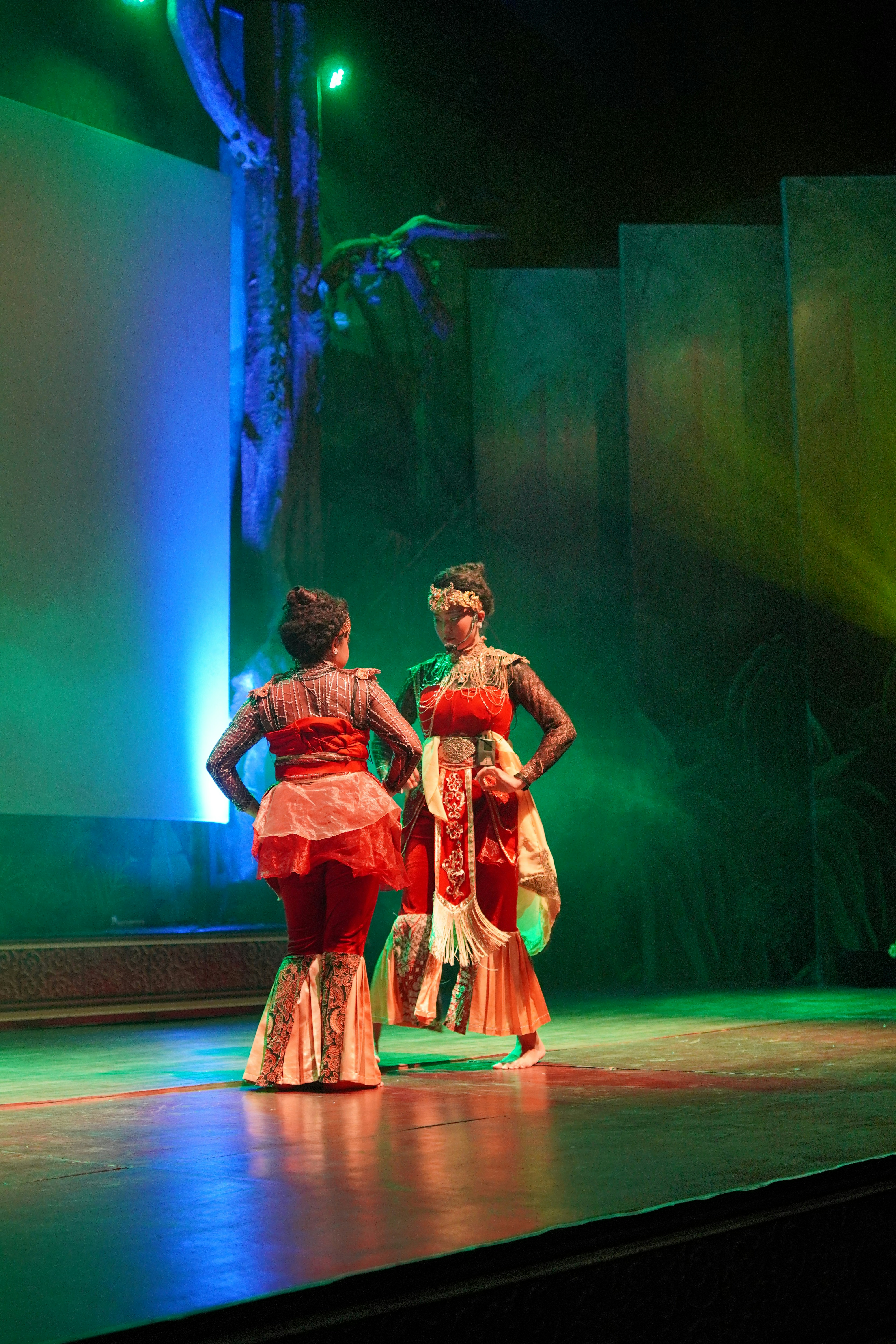 Duo in Crimson: A Traditional Dance Under Stage Lights