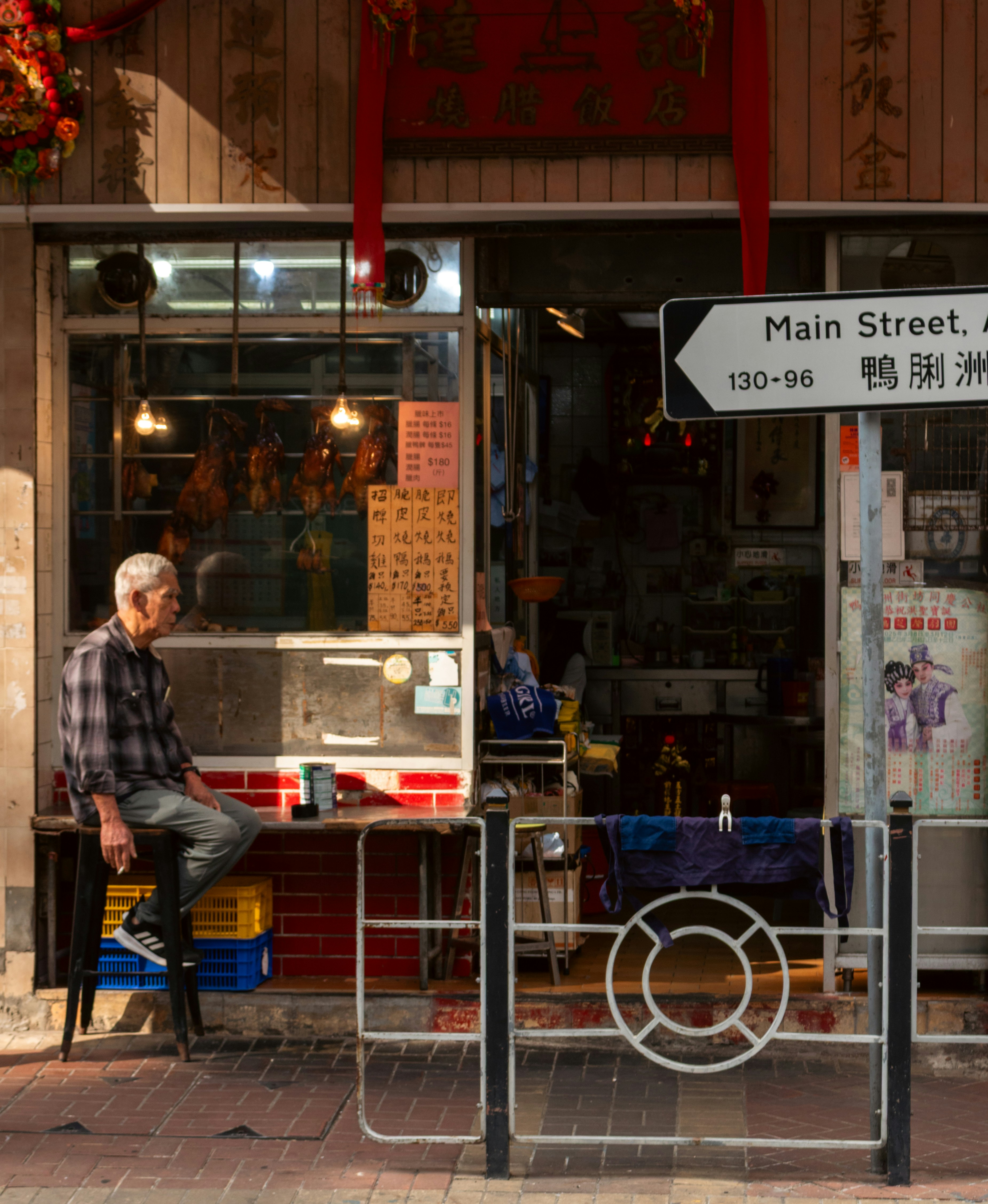 A street-level perspective of a Chinese restaurant on main street in Ap Lei Chau neighborhood in Hong Kong. This shot highlights the everyday rhythm and spatial density of classic Hong Kong district life. Editorial writers can use this image for features on Asian urbanism, local housing, or travel destination guides.