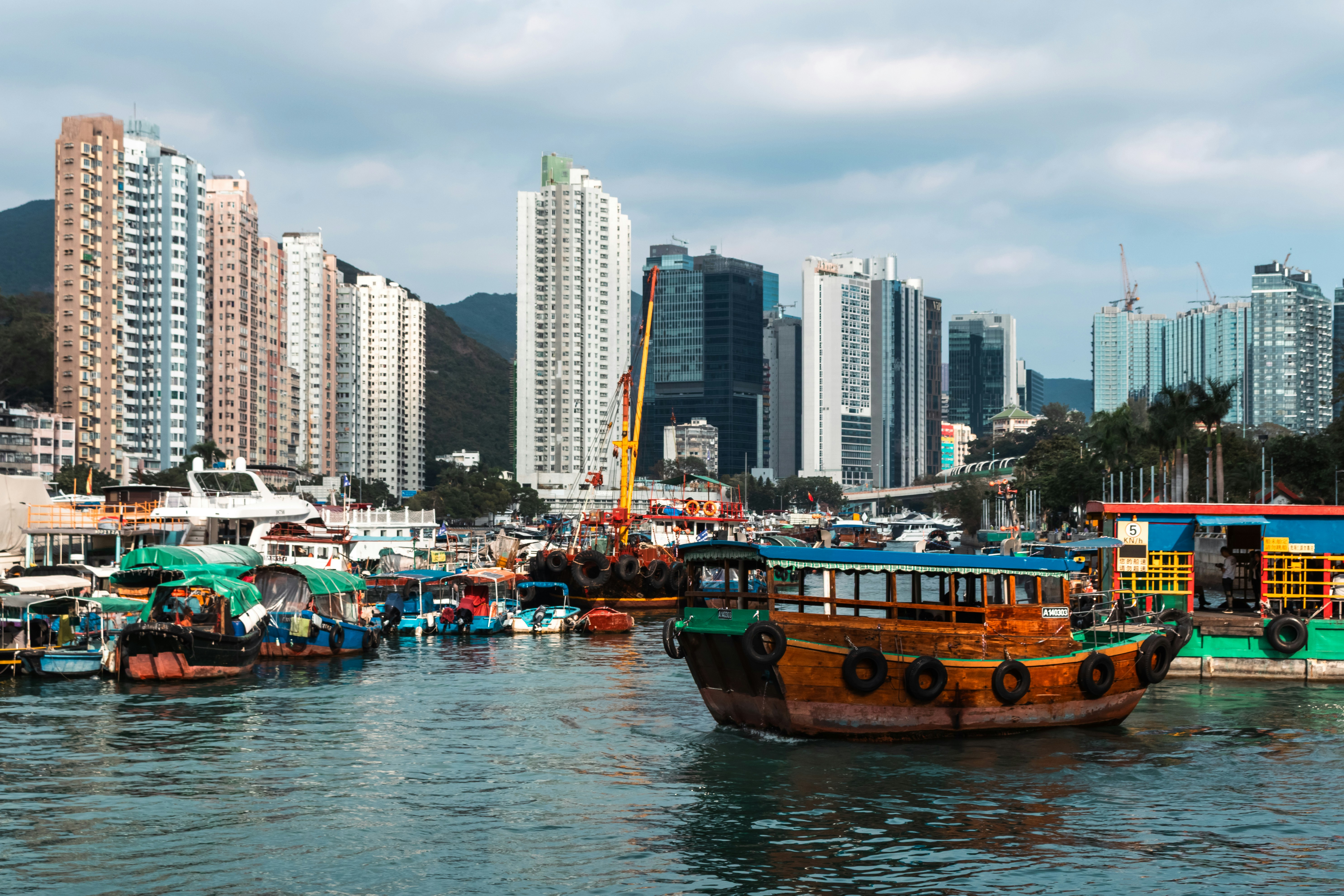 Harbor at Dusk: Boats and Skyline Reflect in Calm Waters