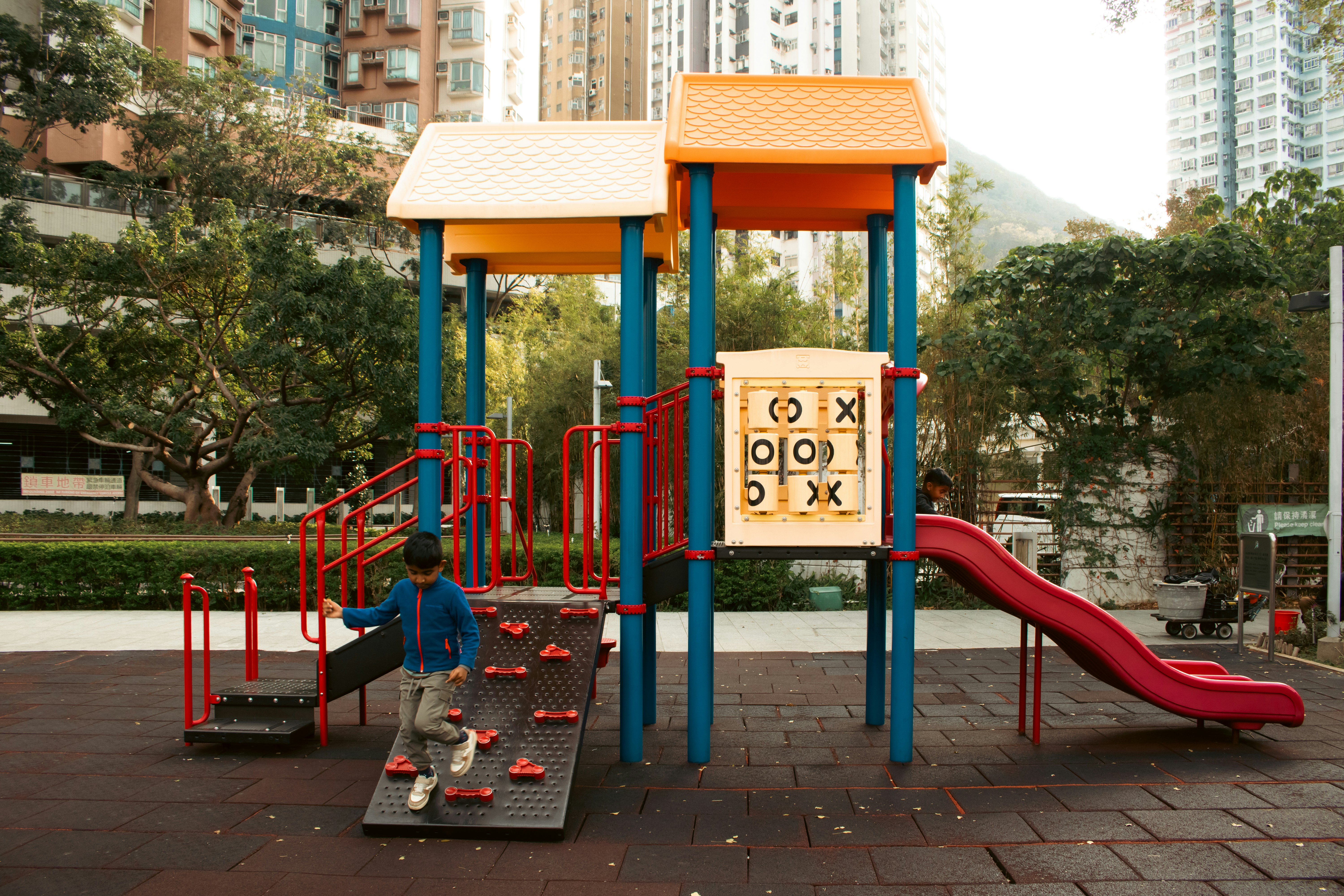 Child Climbing the Red-Rimmed Playground Rock Wall