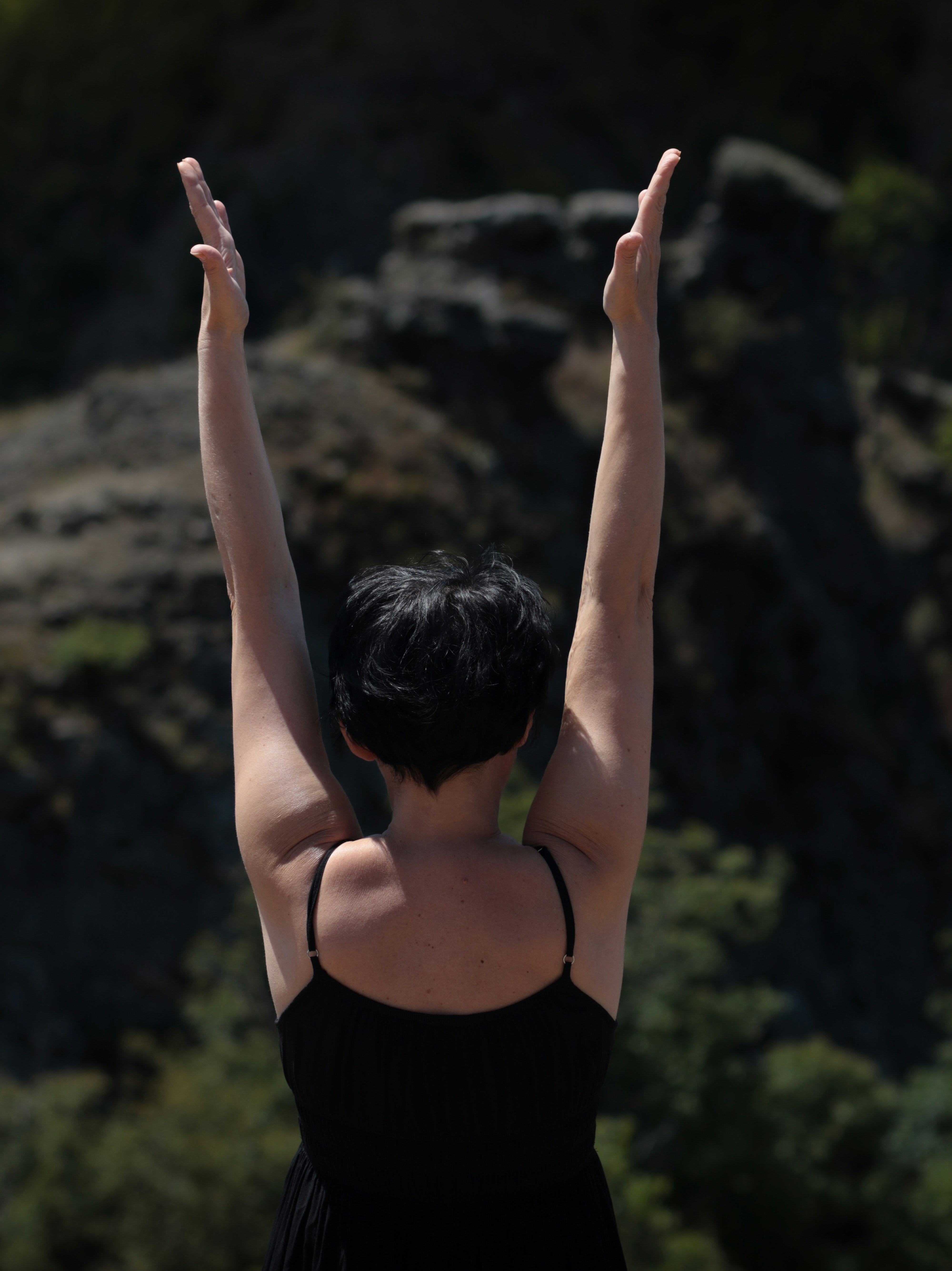 Arms Lifted Toward the Sky: A Quiet Gesture in a Rocky Landscape