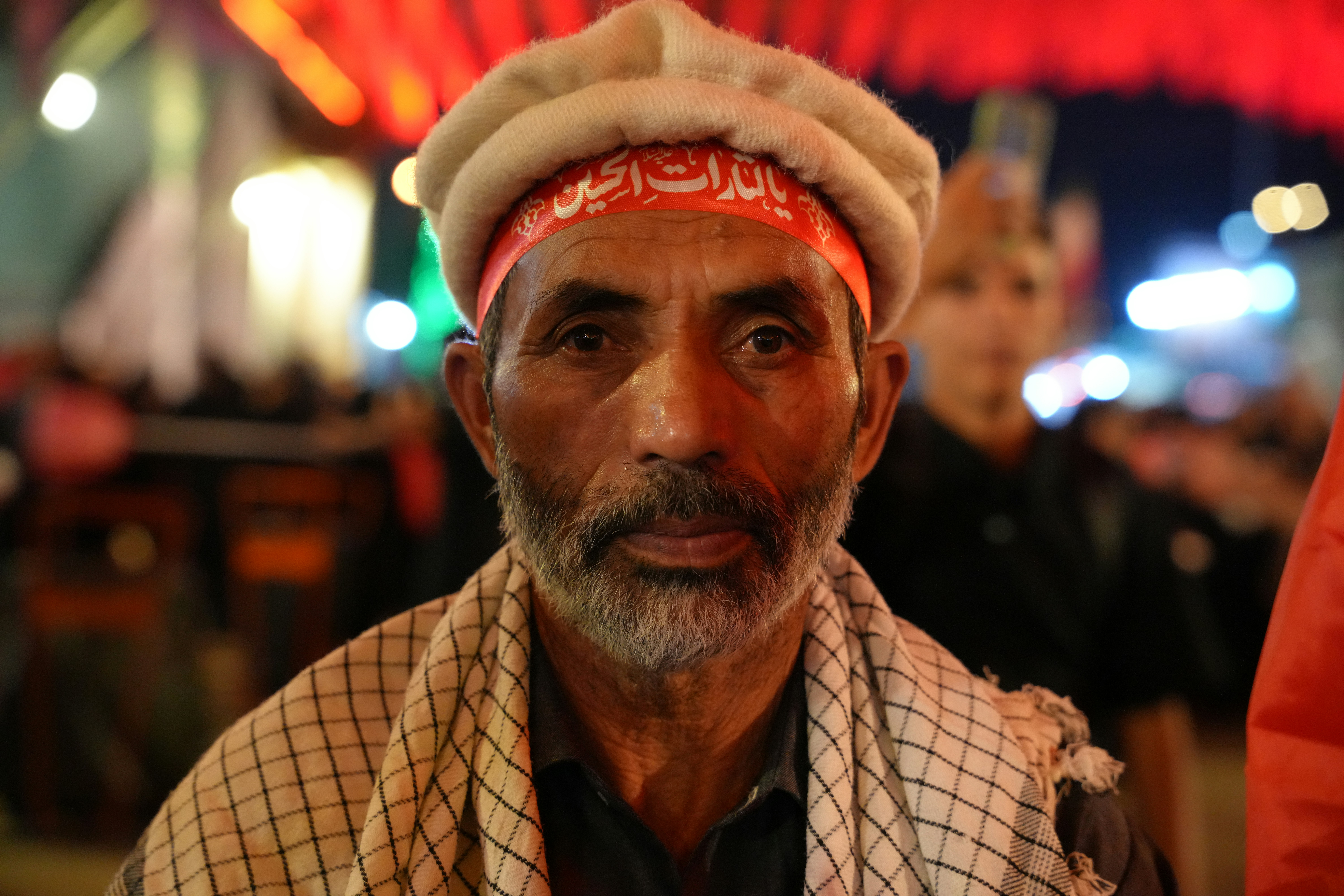 Portrait in the Night Market: A Weathered Seller Under Warm Neon