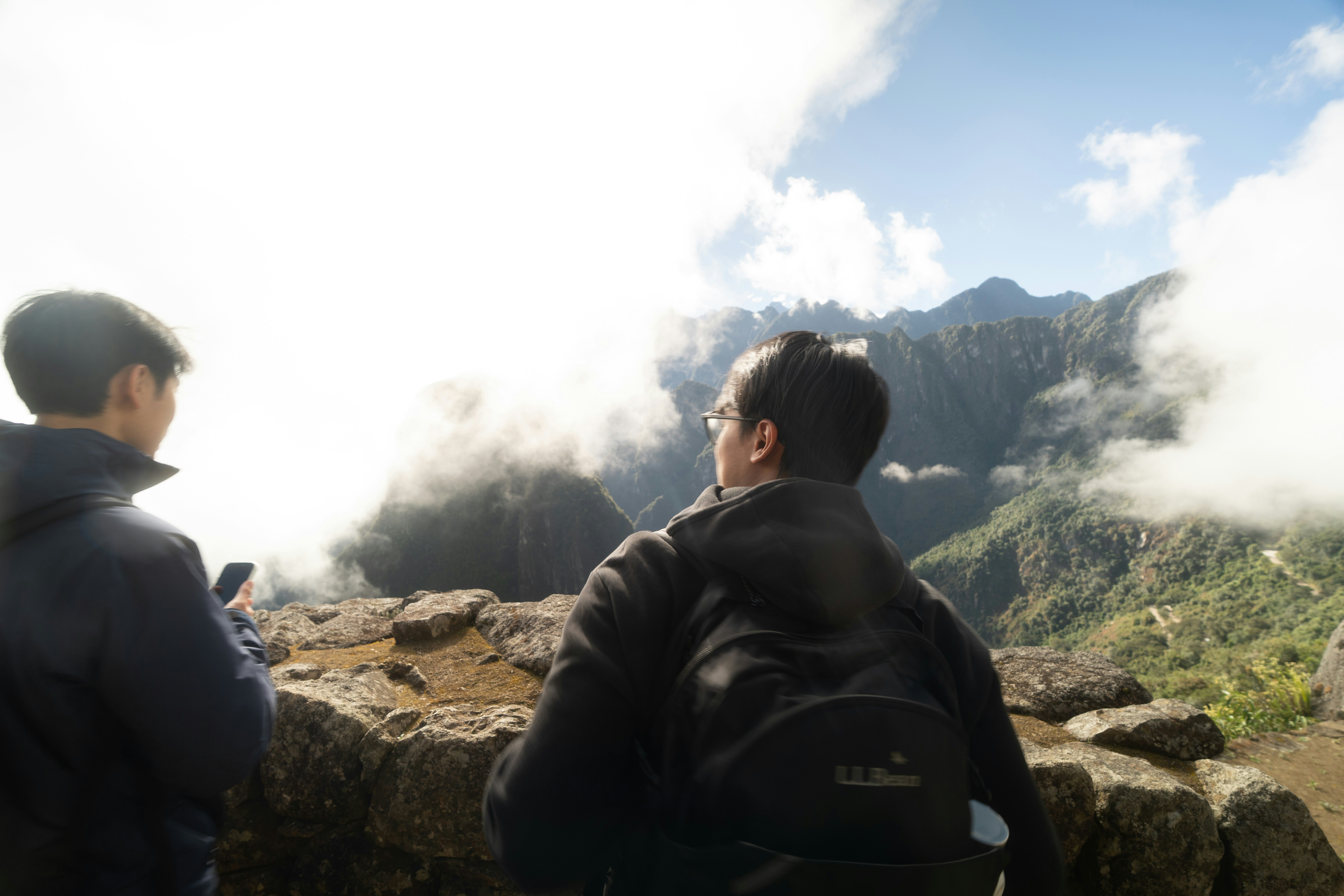 Two hikers at a cloud-kissed mountain overlook