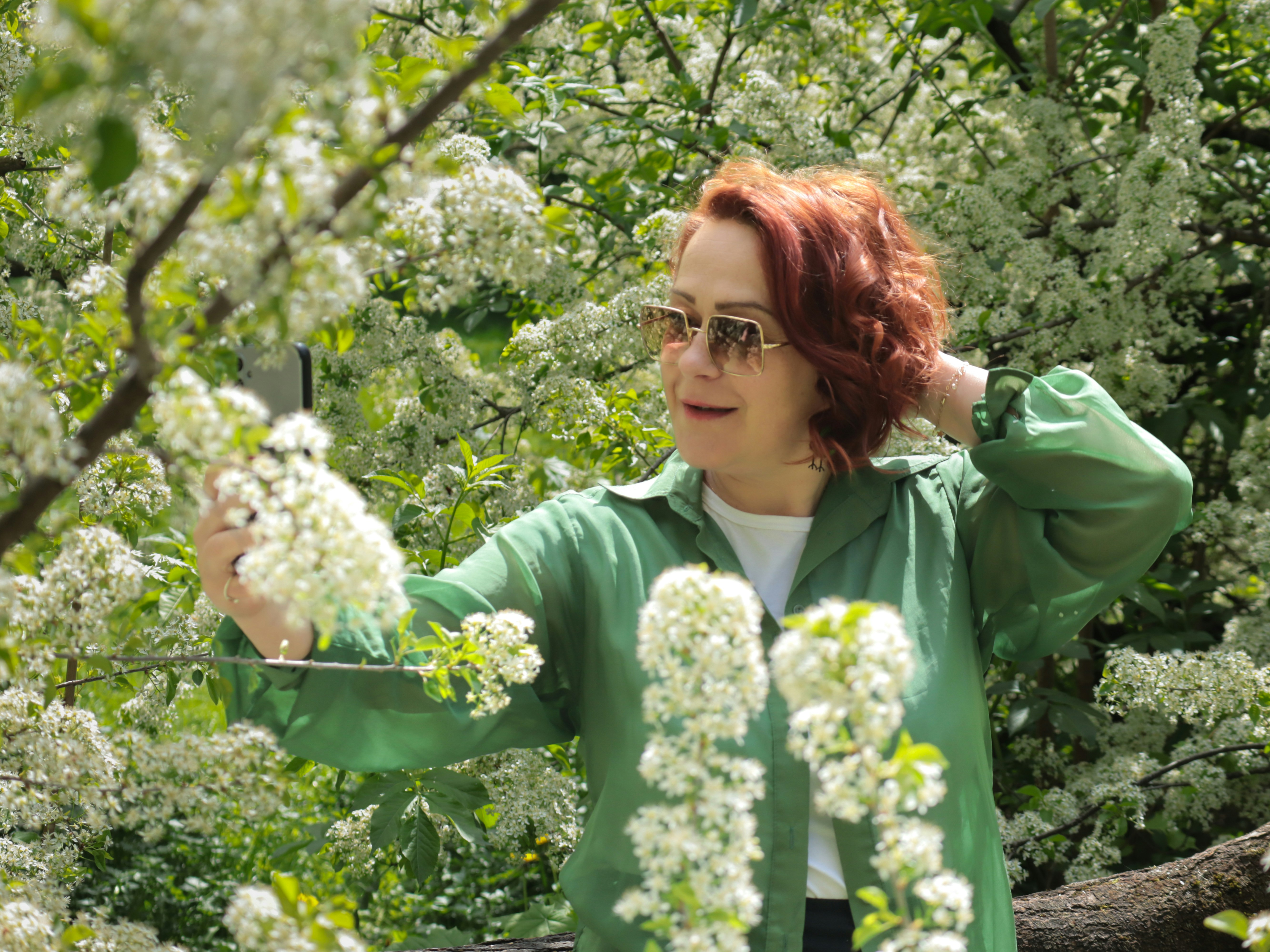 Portrait in Bloom: A Woman in Green Amid White Lilacs