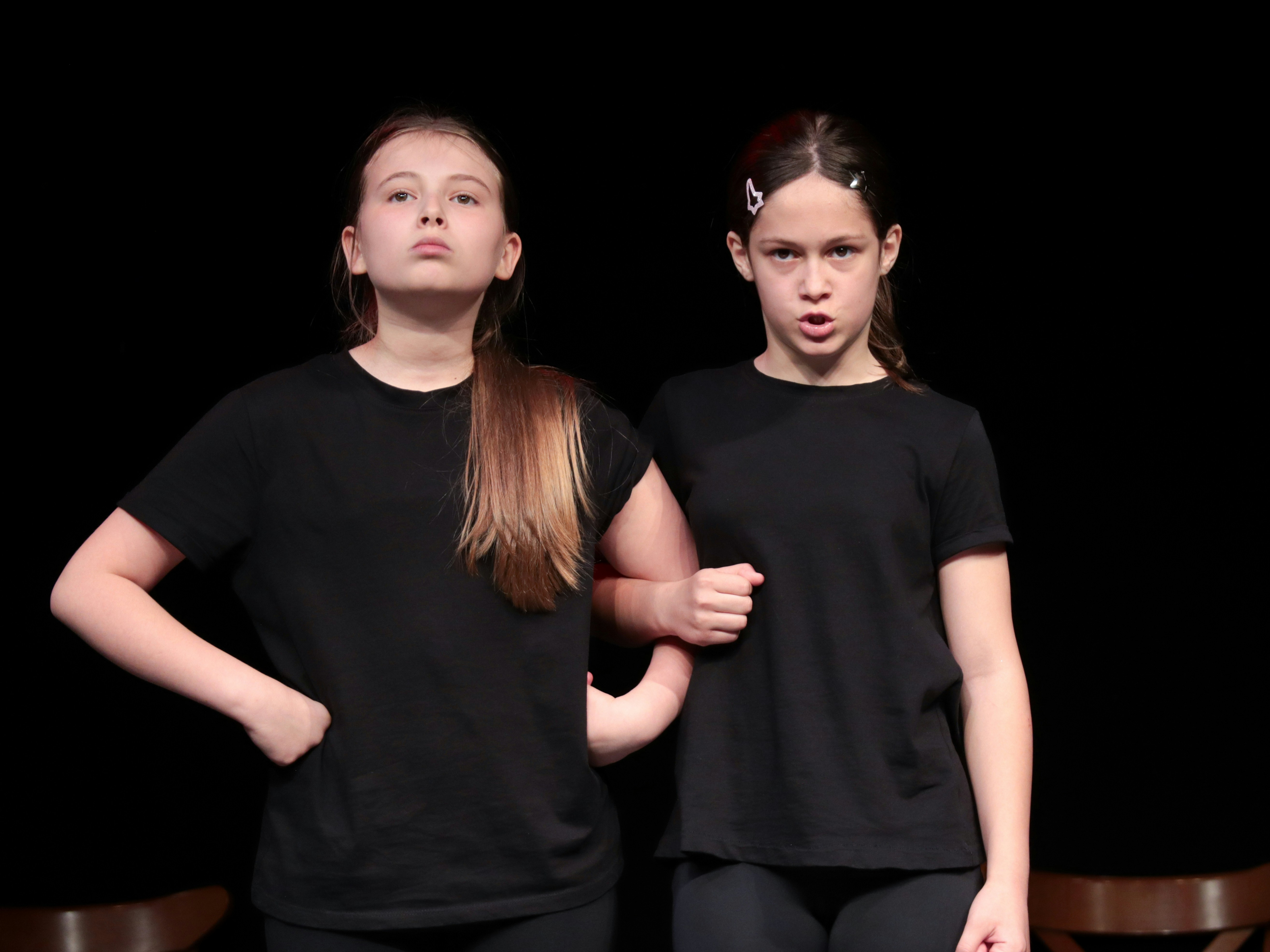 Duo in Black: A Quiet Standoff on a Dark Stage
