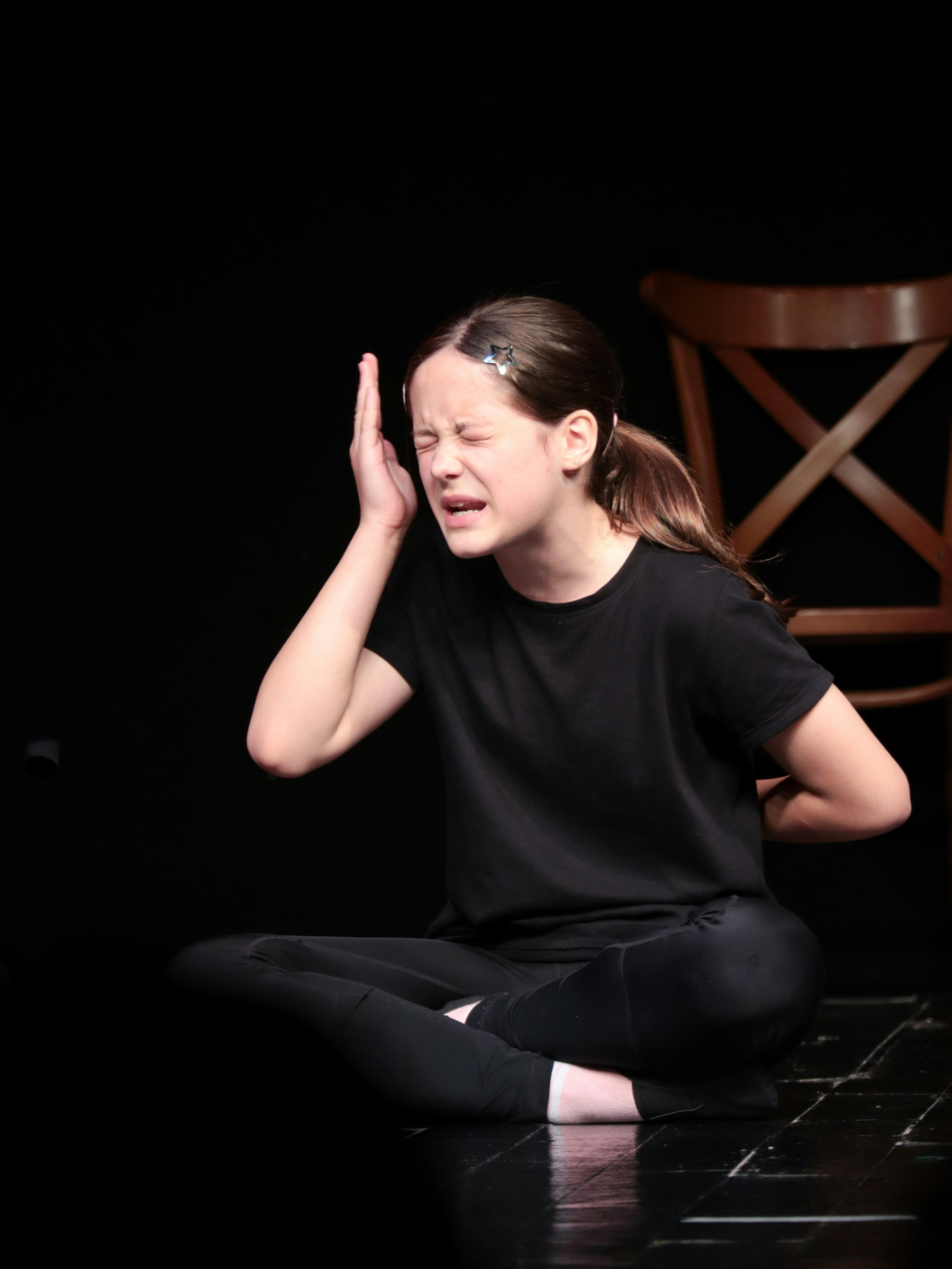 Child on Stage: A Silent Moment with a Shaded Spotlight
