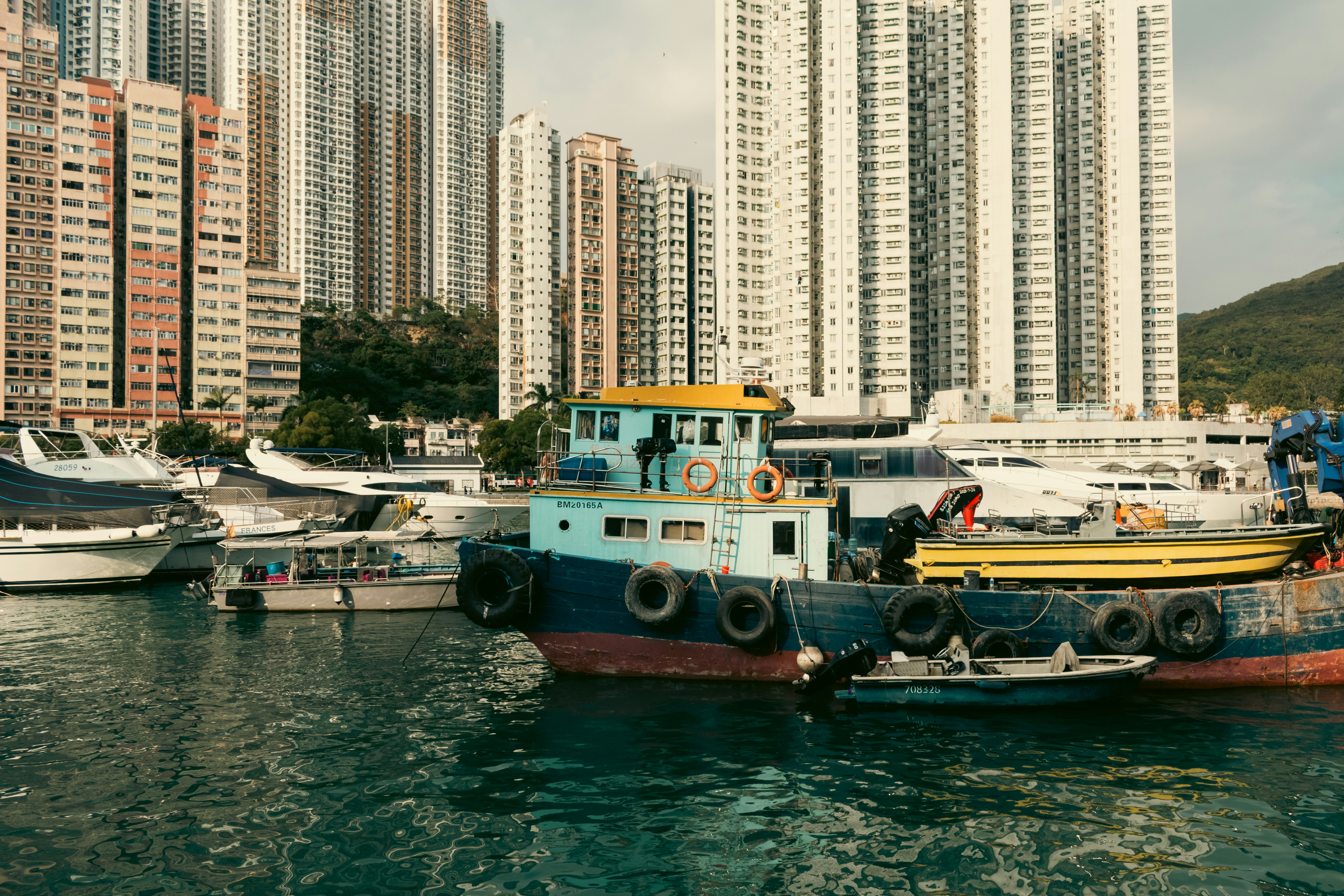 Colorful Tugboat Row at a Harbor Backdrop of High-Rise Glass