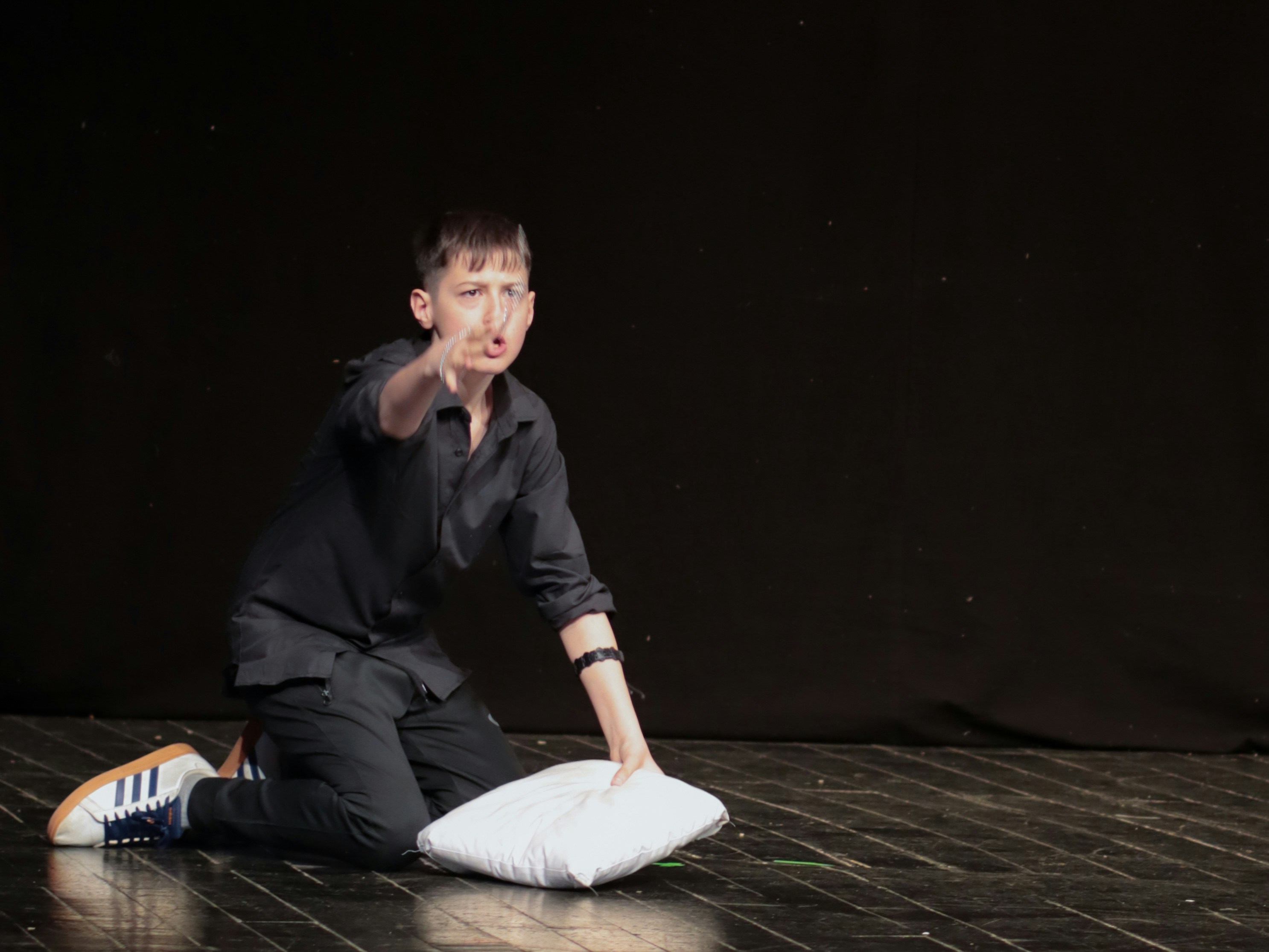 Curtain Call: A poised performer reaches toward the audience from a dark stage