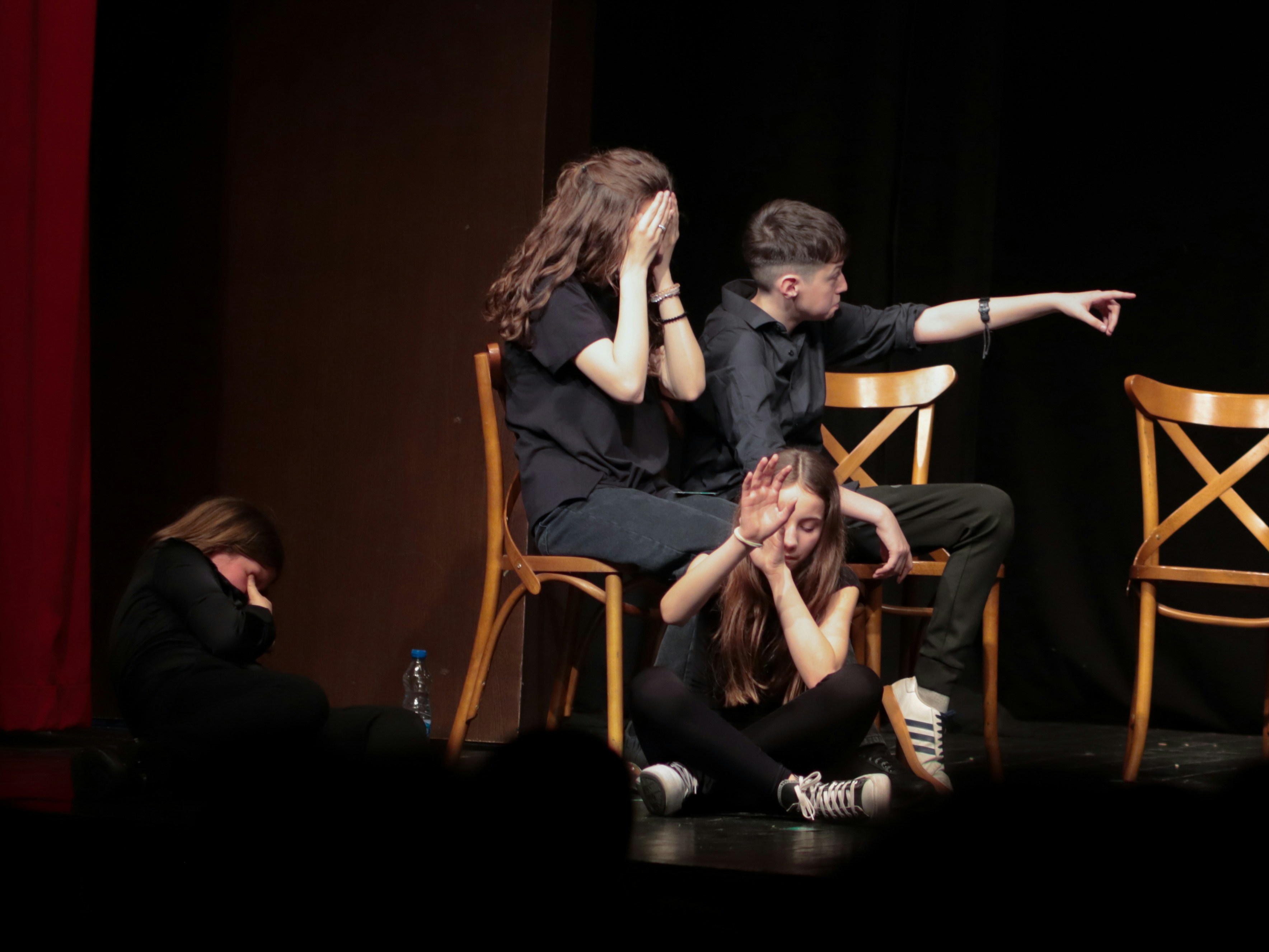 Disrupted Quiet on Stage: Three Teens in a Pause Between Moments
