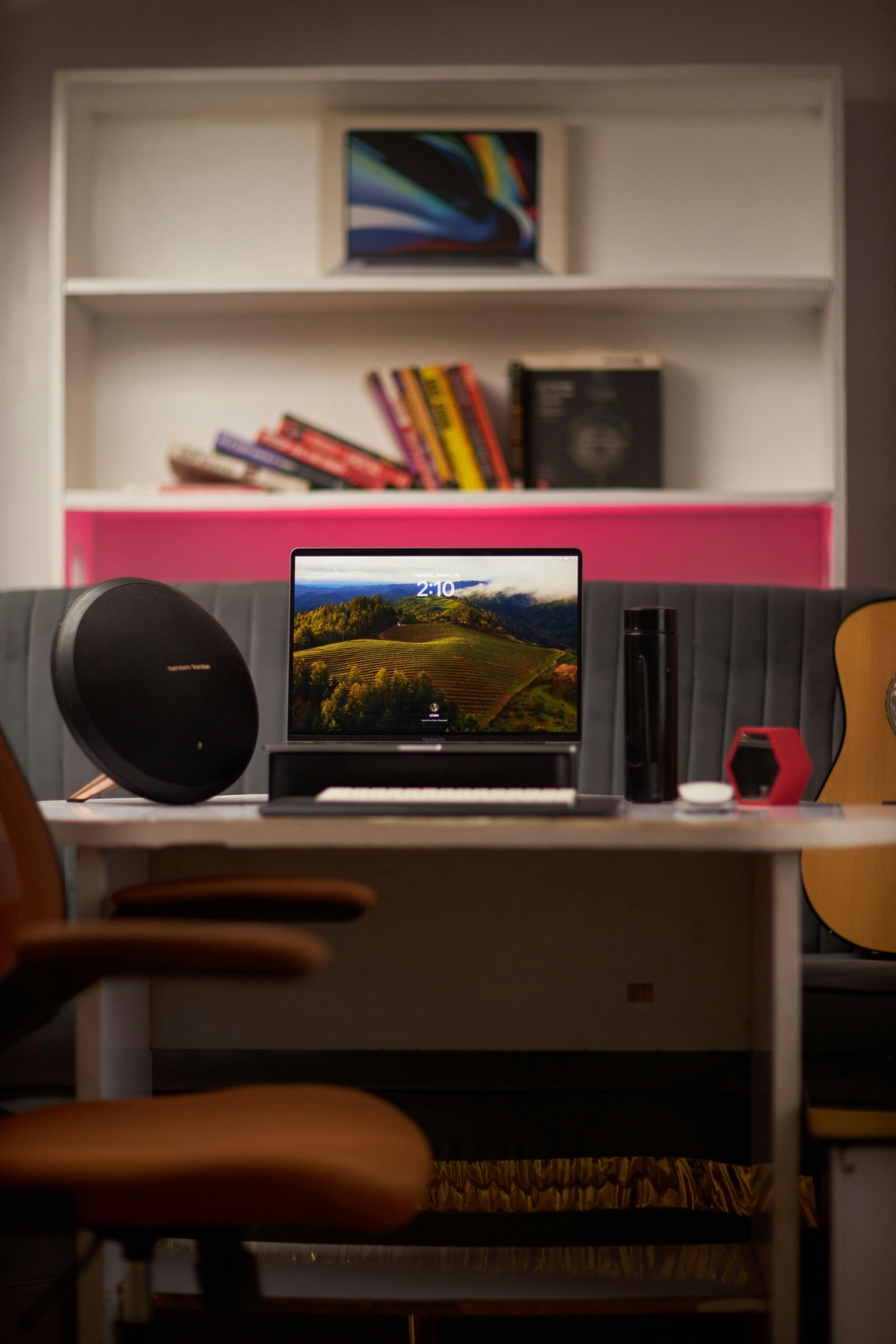 Studio desk with a centered laptop displaying a scenic wallpaper