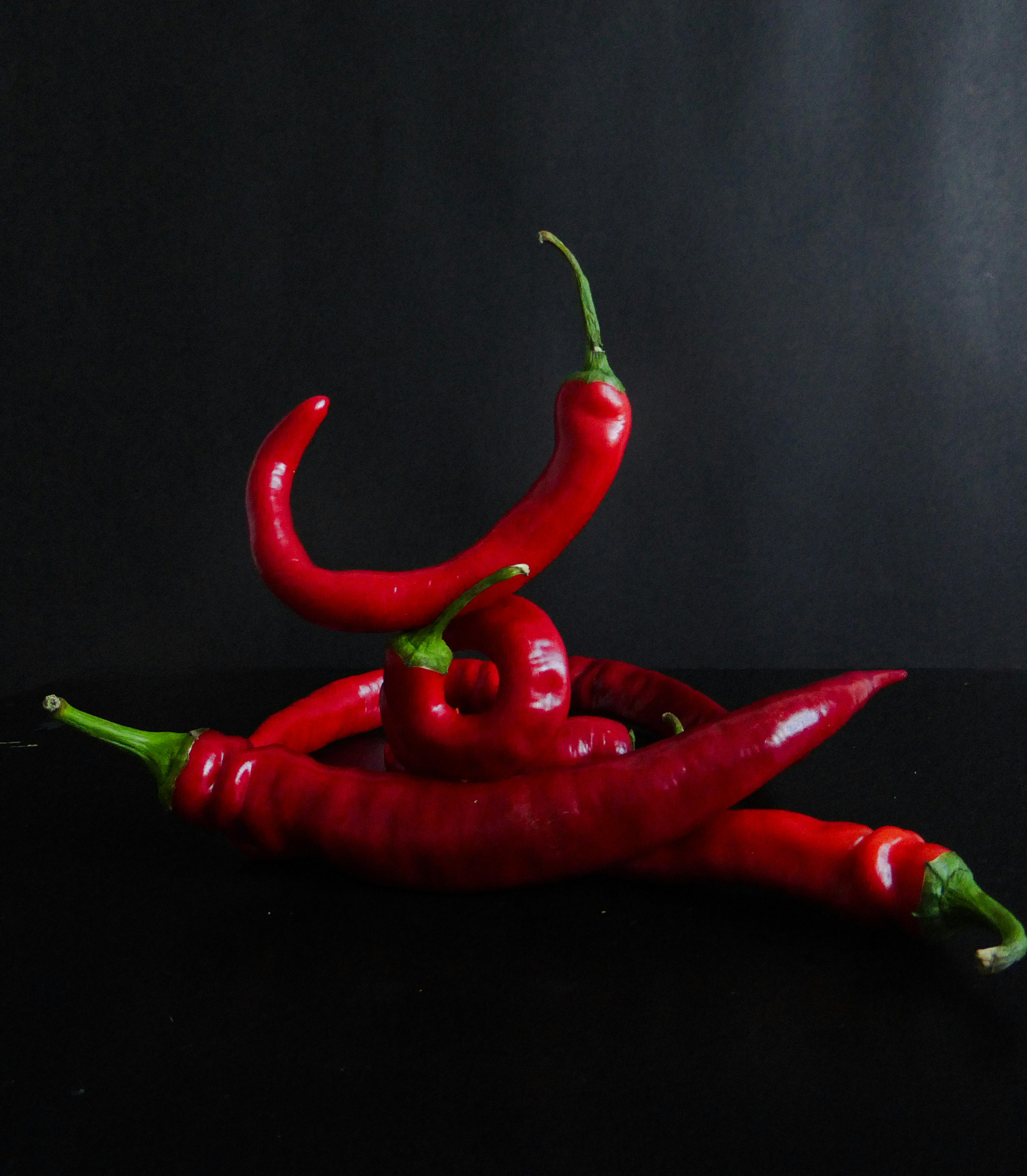 Red Pepper Ballet: A Stack of Pepper Stems Against a Velvet Black