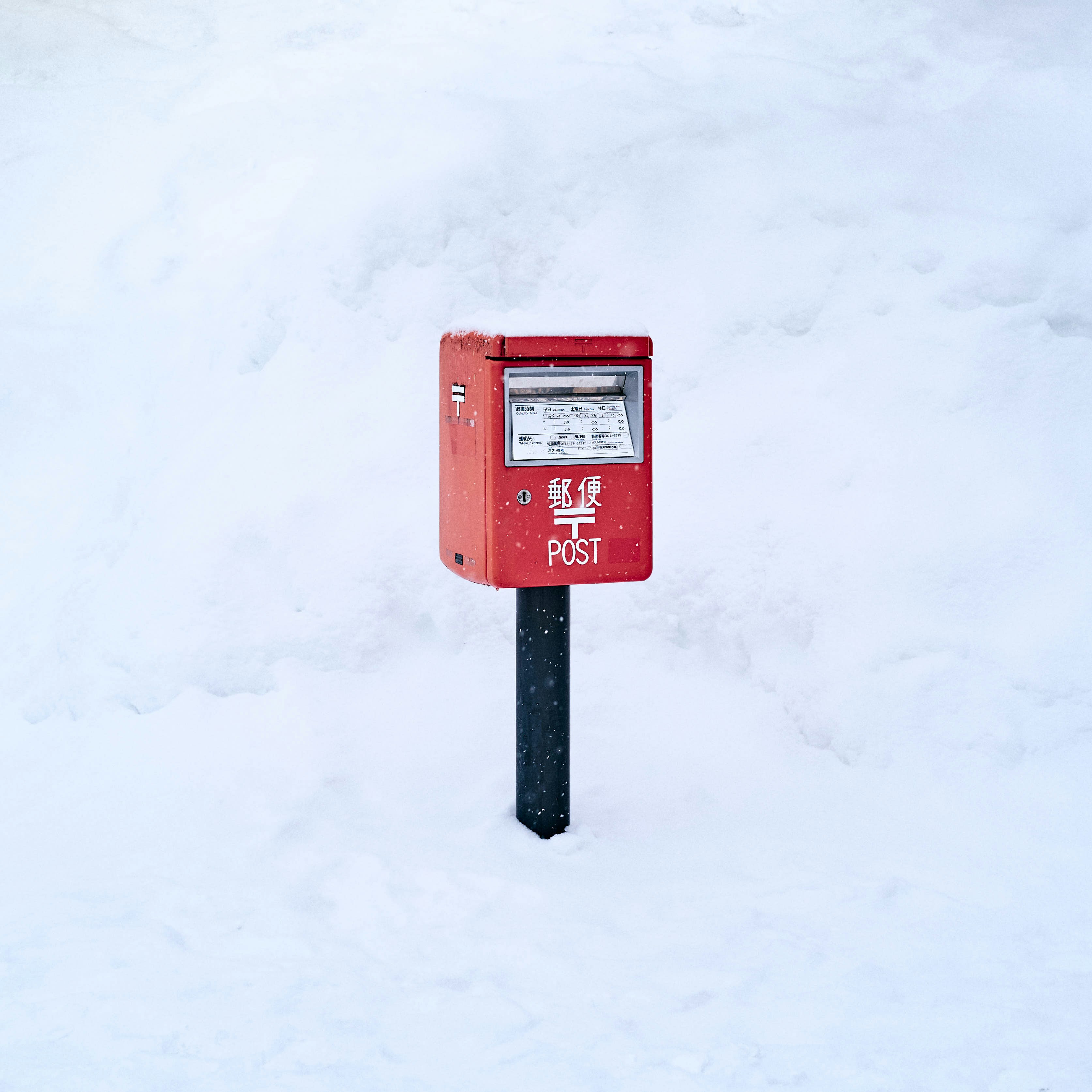 Red Postbox in Powdery Snow: A Quiet Winter Standout