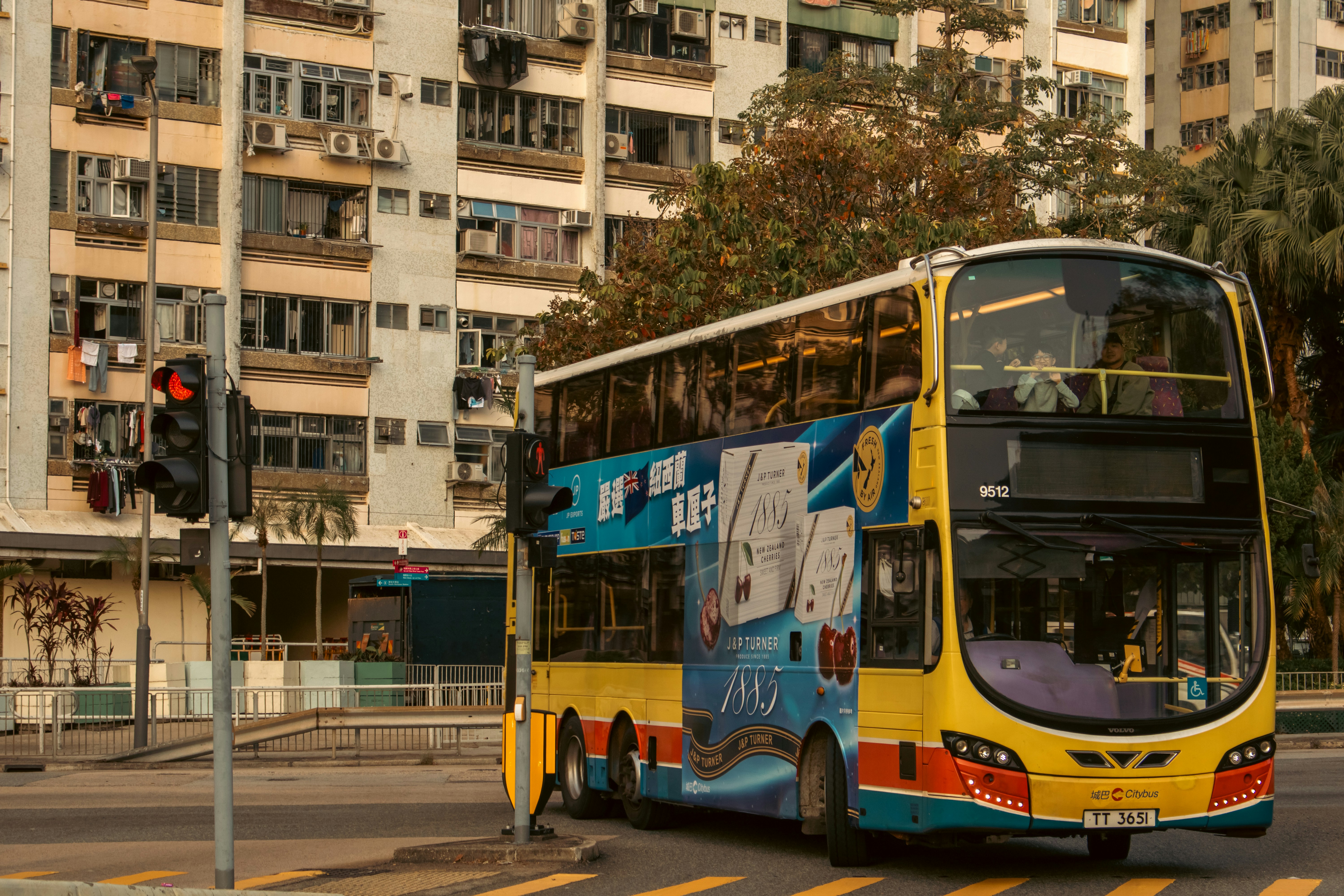 City Bus in Motion: Colorful Double-Deck Gliding by Residential Towers
