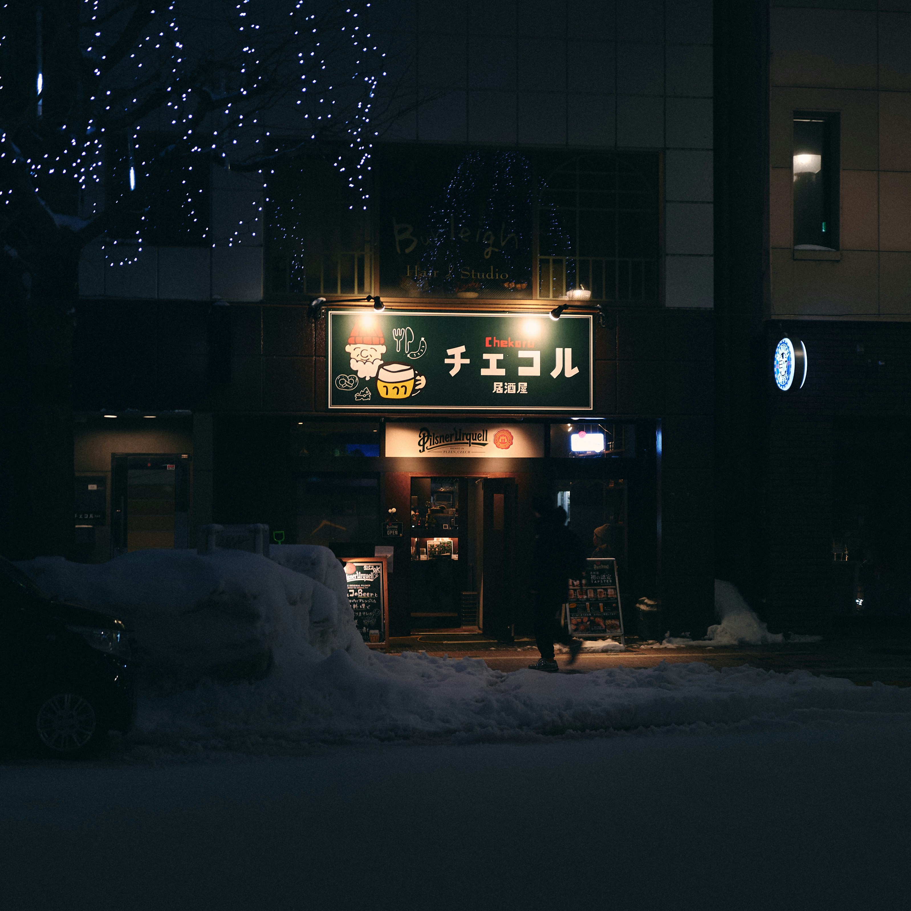 Night Signage and Snowfront: Cozy Café Glow in the Urban Quiet