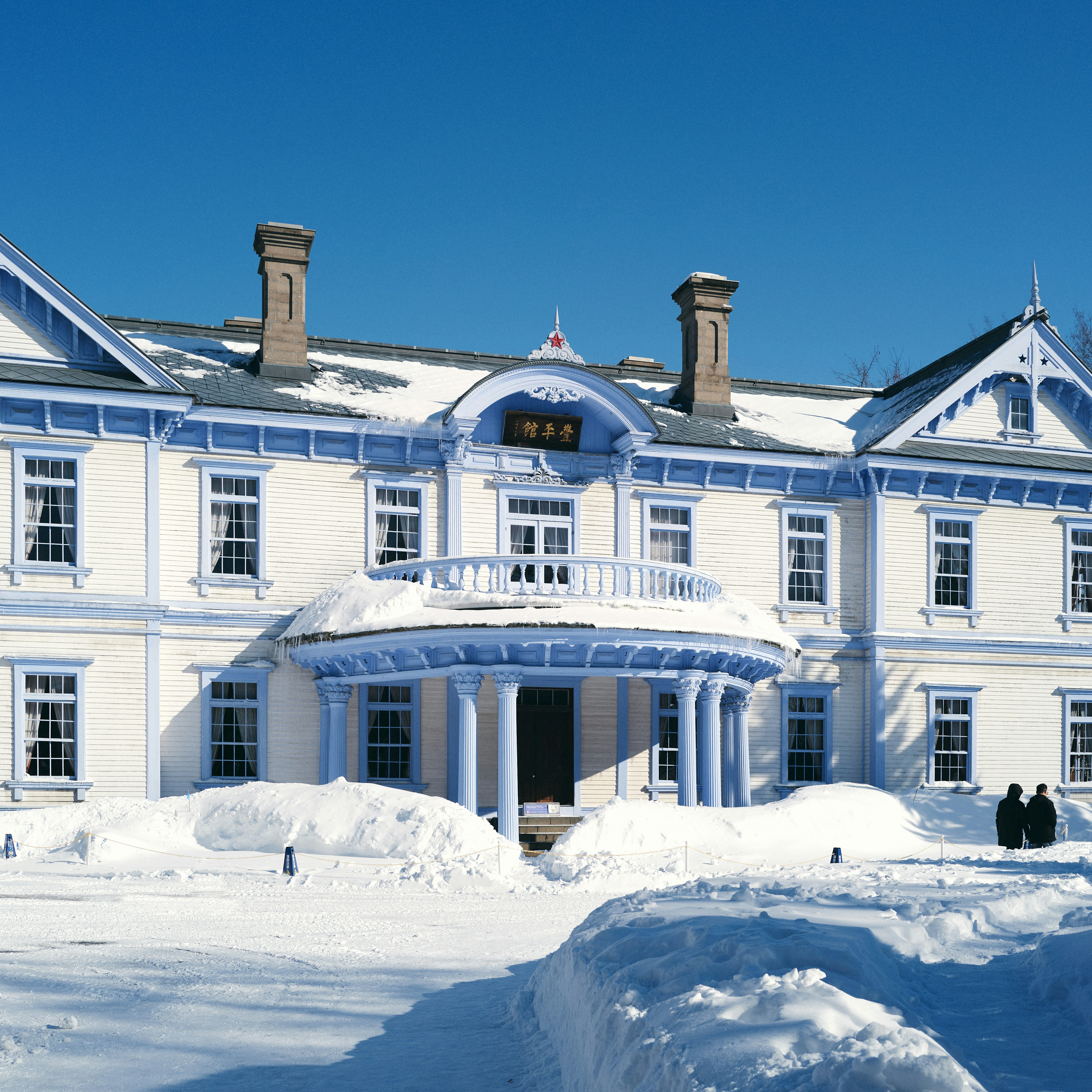 Snowbound Manor: A Classic Facade Framed by Winter Light