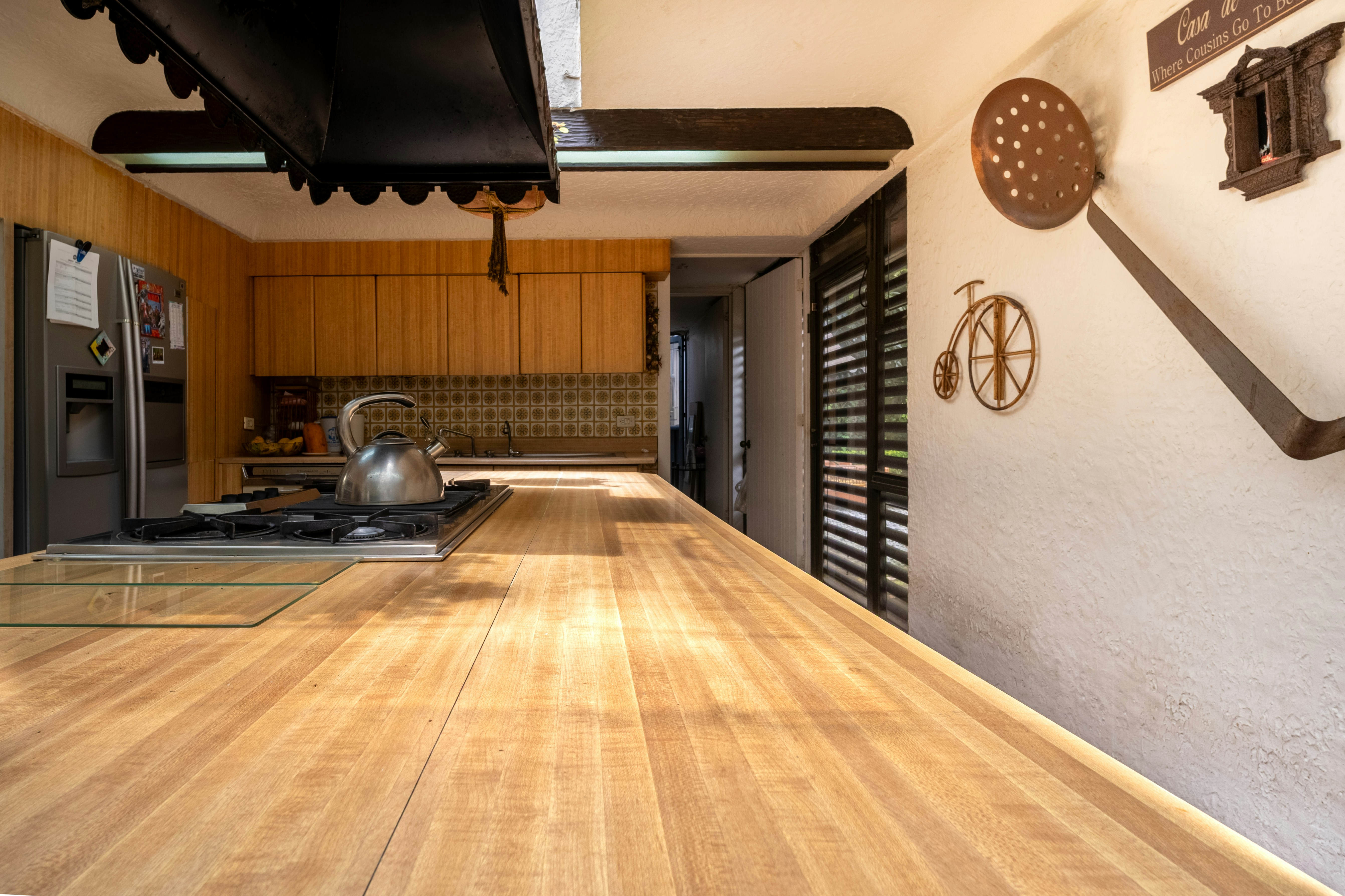 Sunken Bar Kitchen: A Golden-wood Counter Leading to a Quiet Corridor