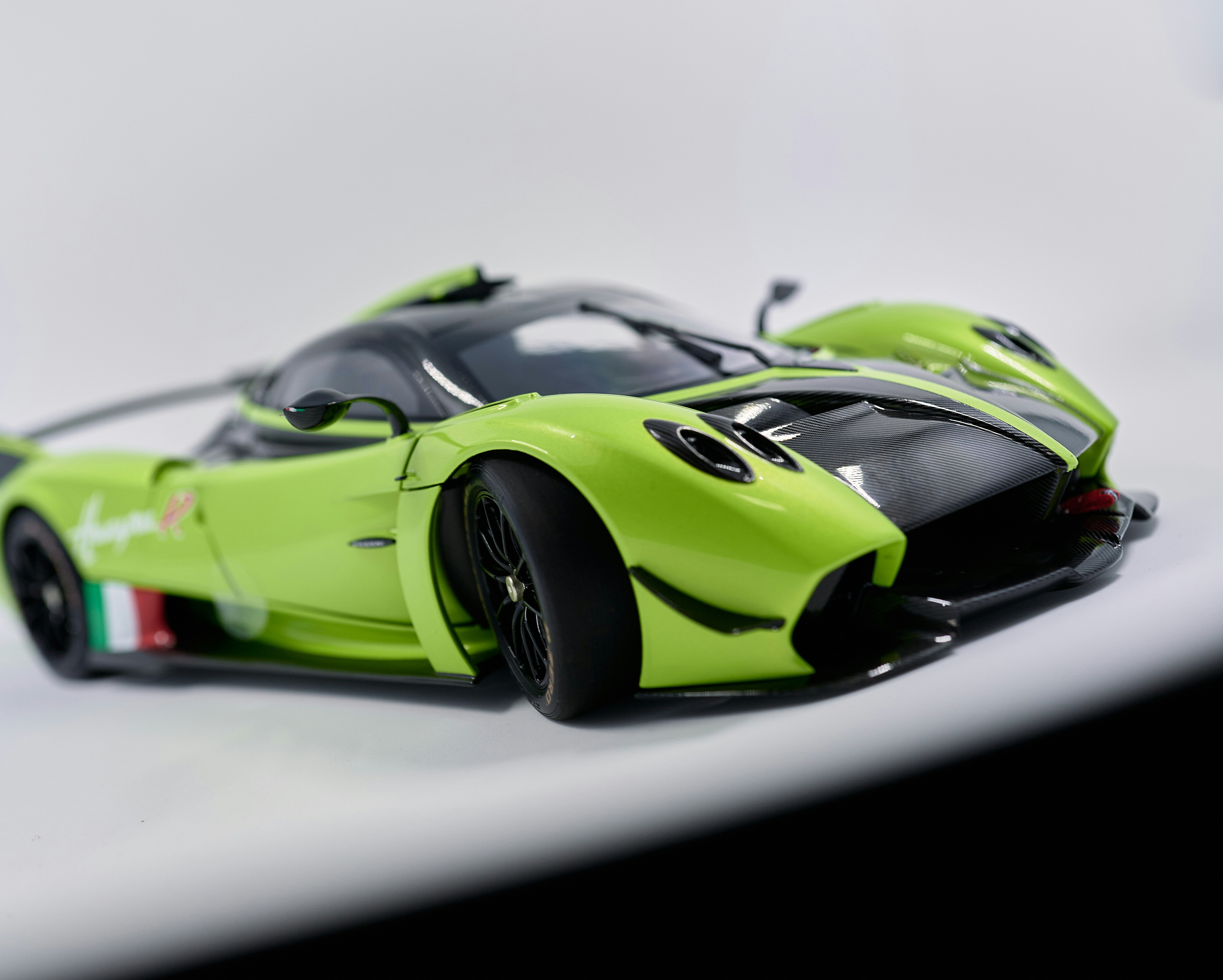 Lime‑green hypercar dashes across a white stage