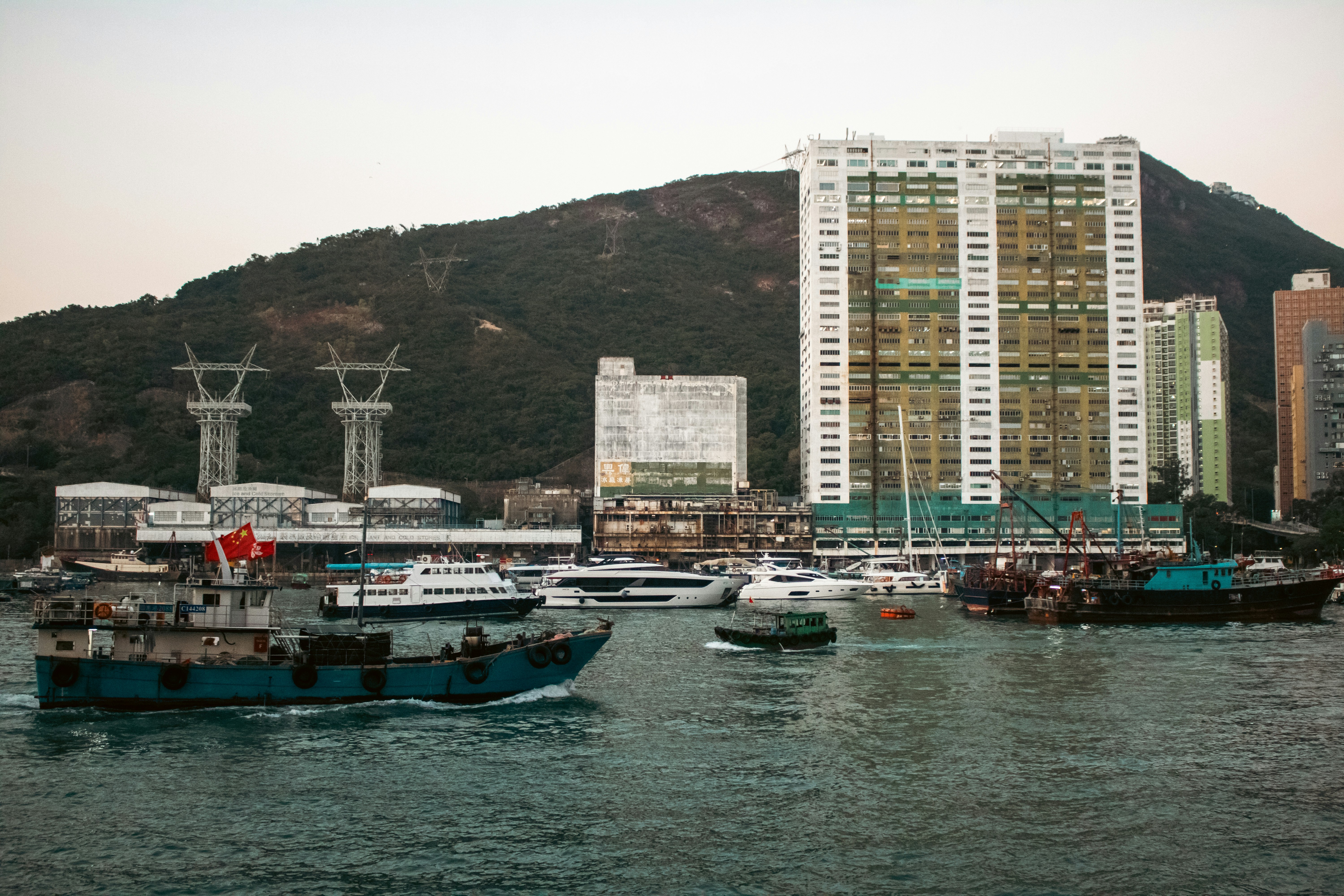 Harbor Wake: Boats, Buildings, and a Hillside Backdrop