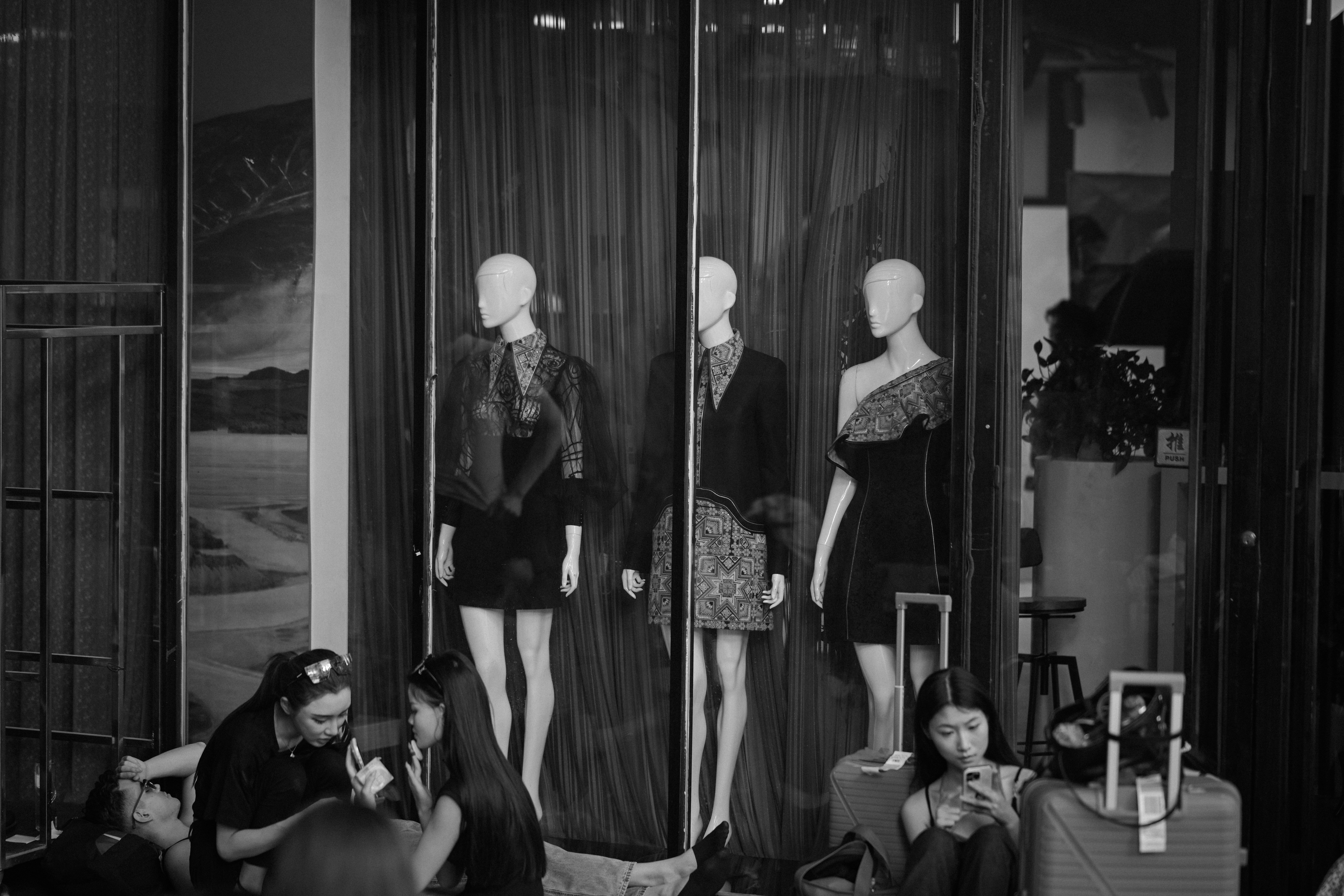 Storefront Mirage: Fashion Mannequins Beneath Curtain Veils