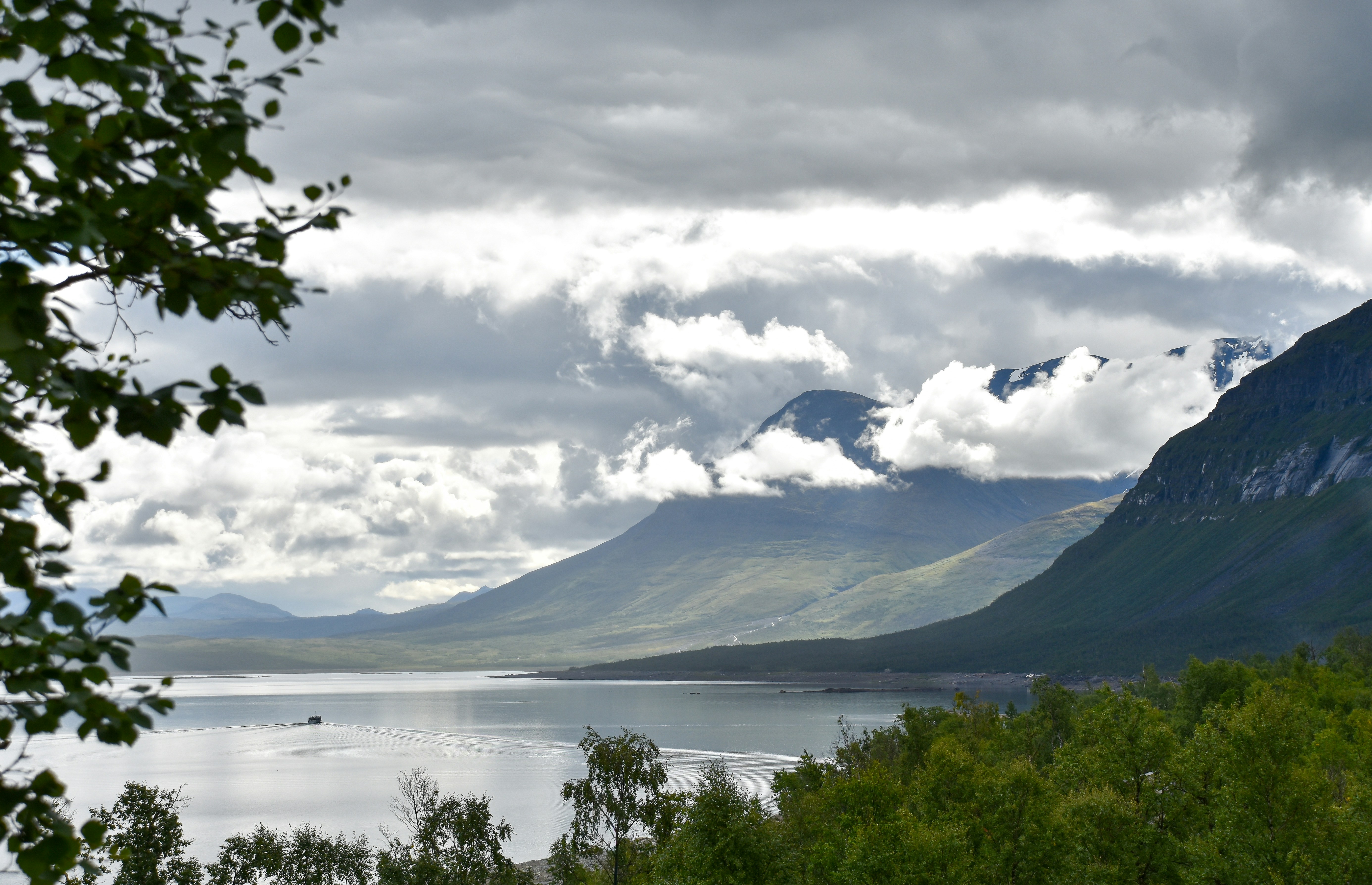 Luminous Fjord Beneath Cloud-Drawn Peaks