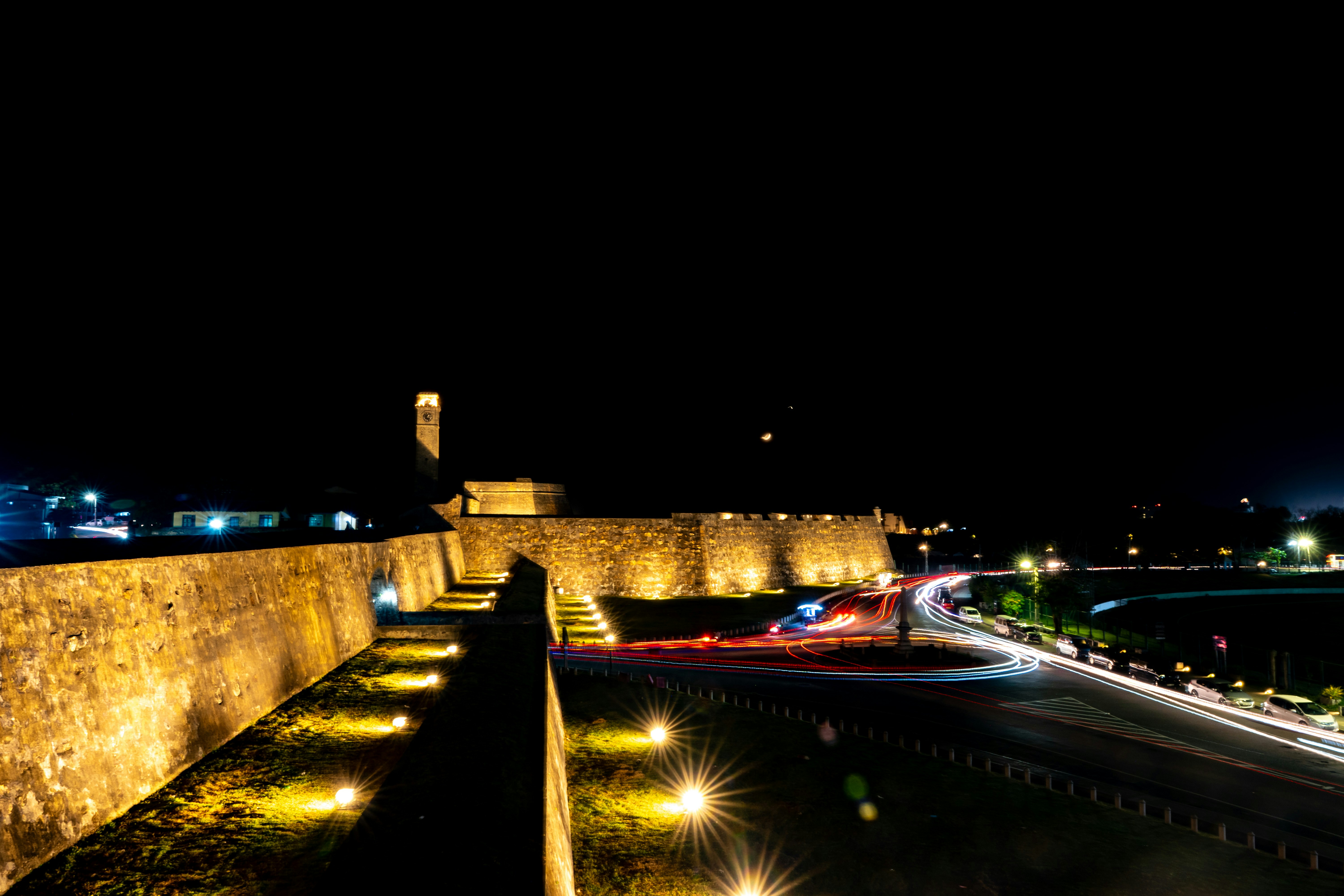 Night Fort Gate: Illuminated Stone Walls and Moving Lights