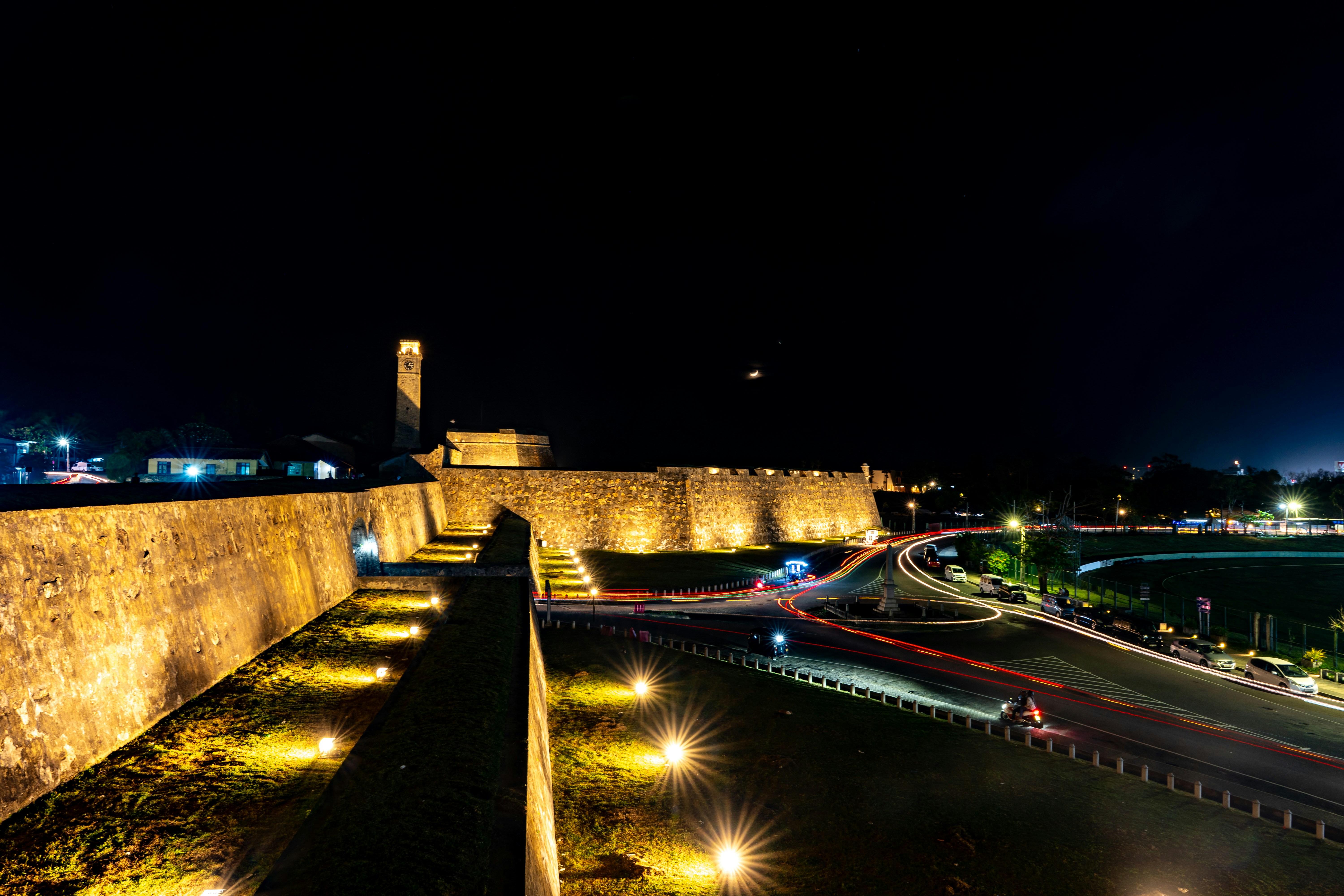 Moonlit Bastion and Neon Veins: Nighttime Overlook of a Historic Fort and Traffic Corridor