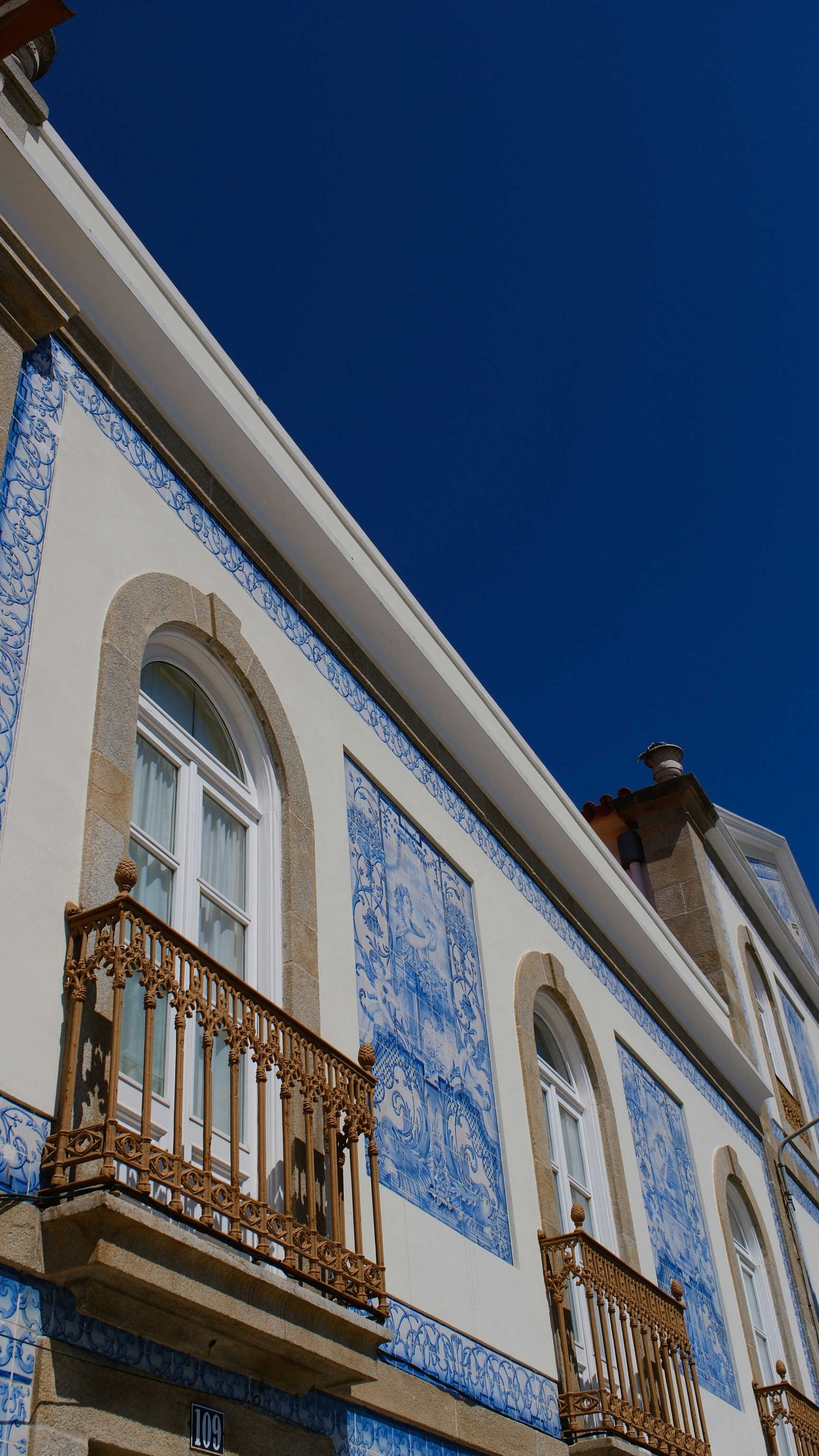 Blue Tiles and Iron Balconies Under a Clear Sky