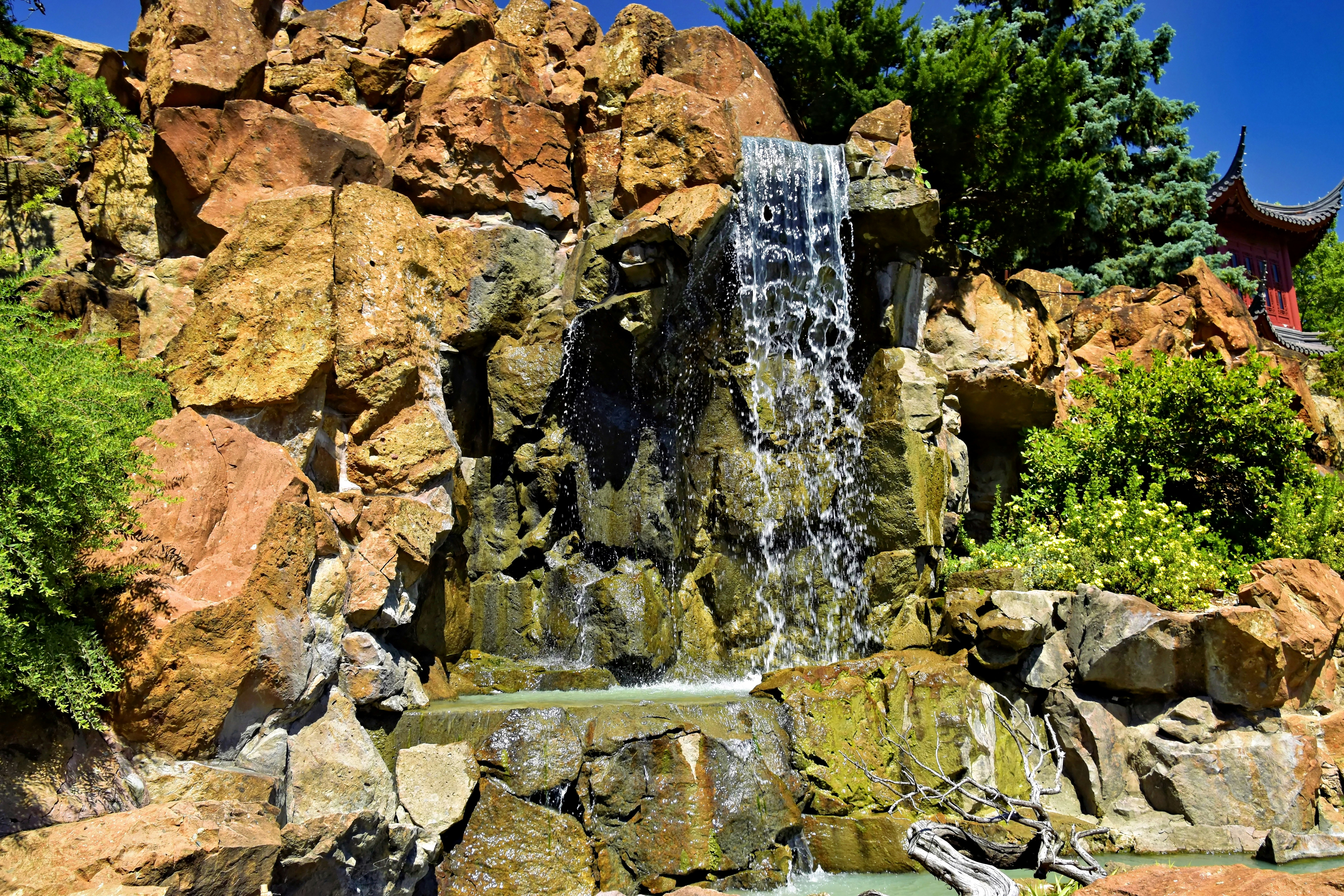 Stone Cascade: A Tranquil Garden Waterfall Framed by Rugged Rocks