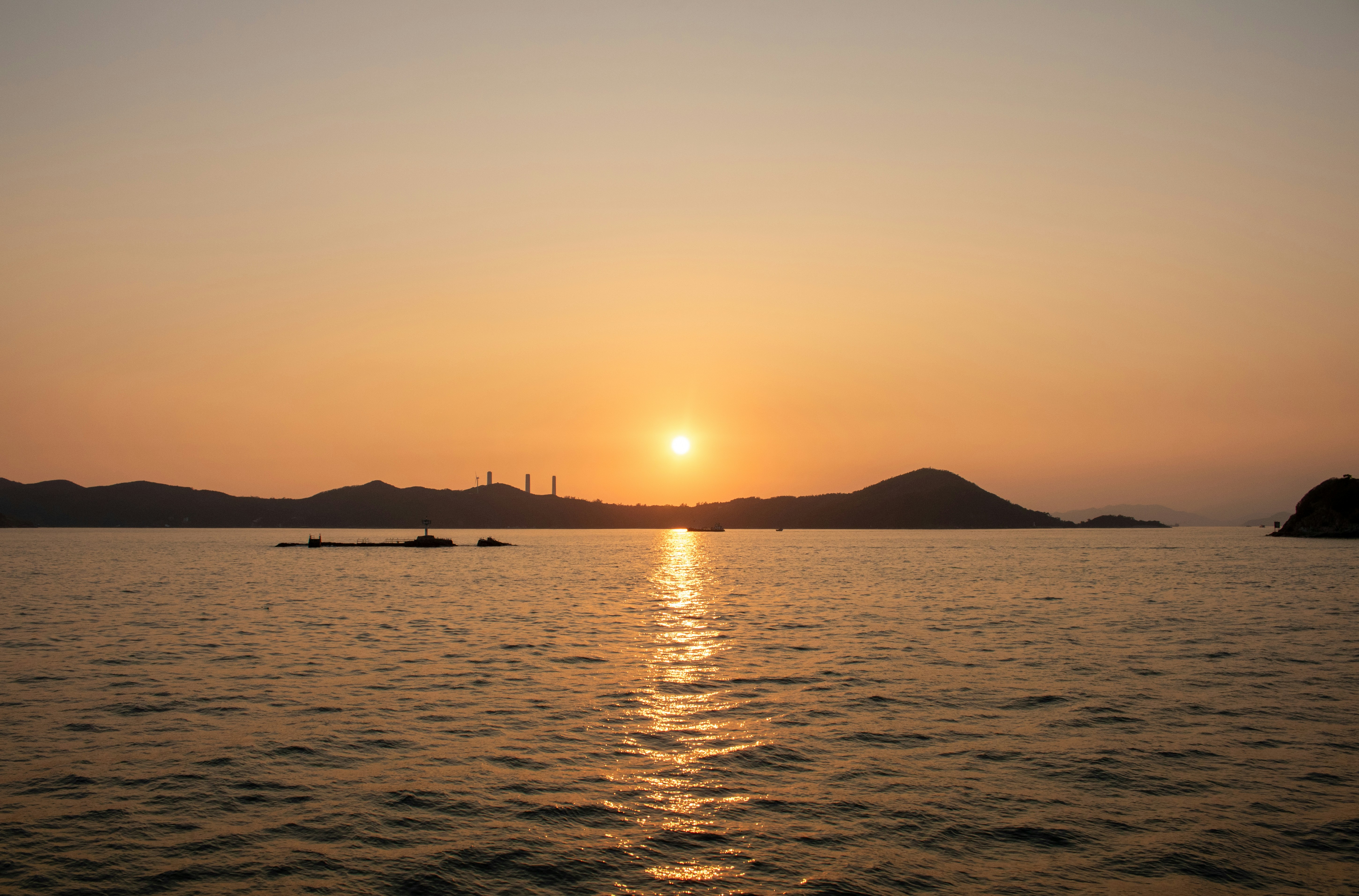 Sunlit Horizon: Quiet Boats and a Cresting Tide