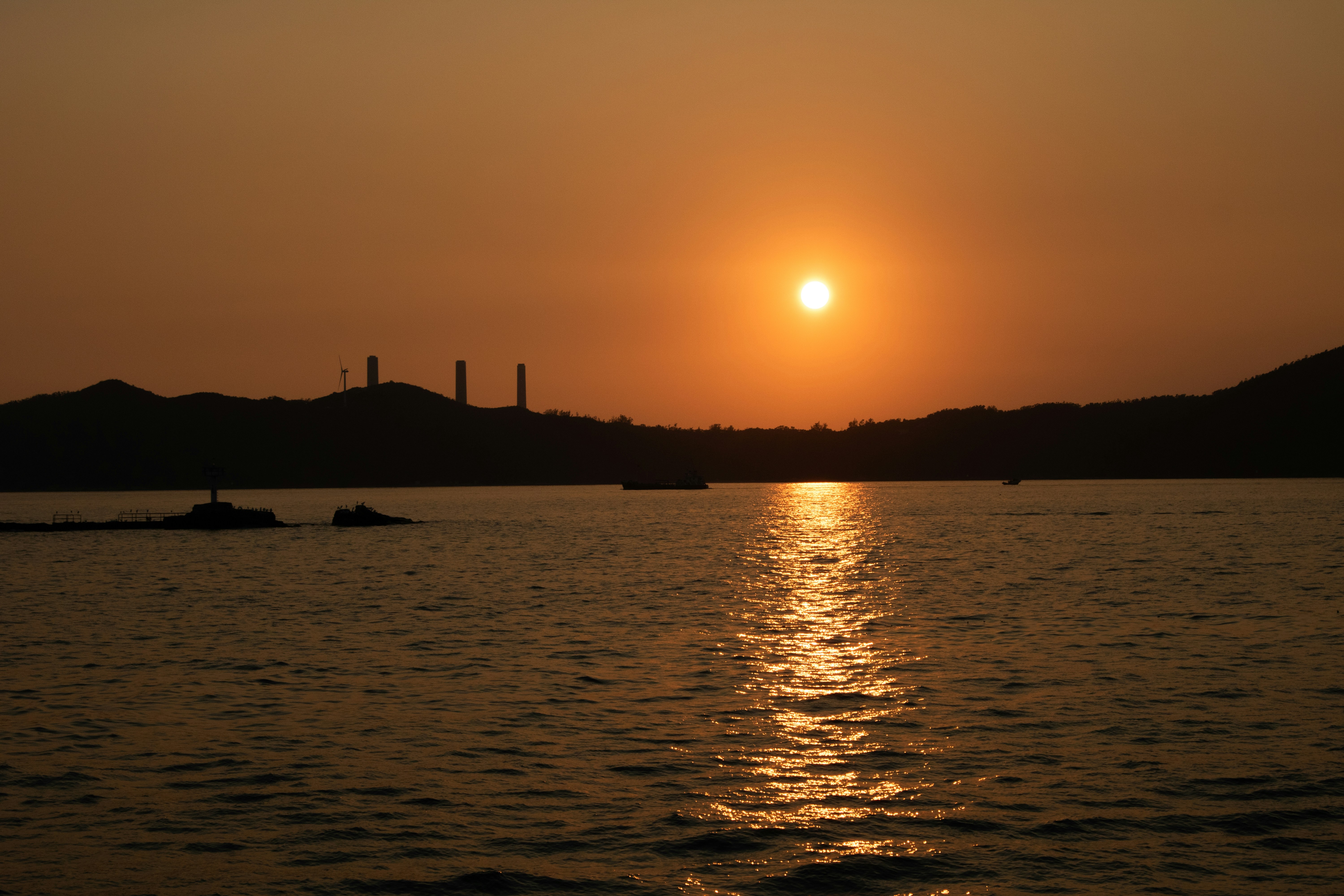 Sunset Over Quiet Waters: A Silhouette Crossing the Dusk