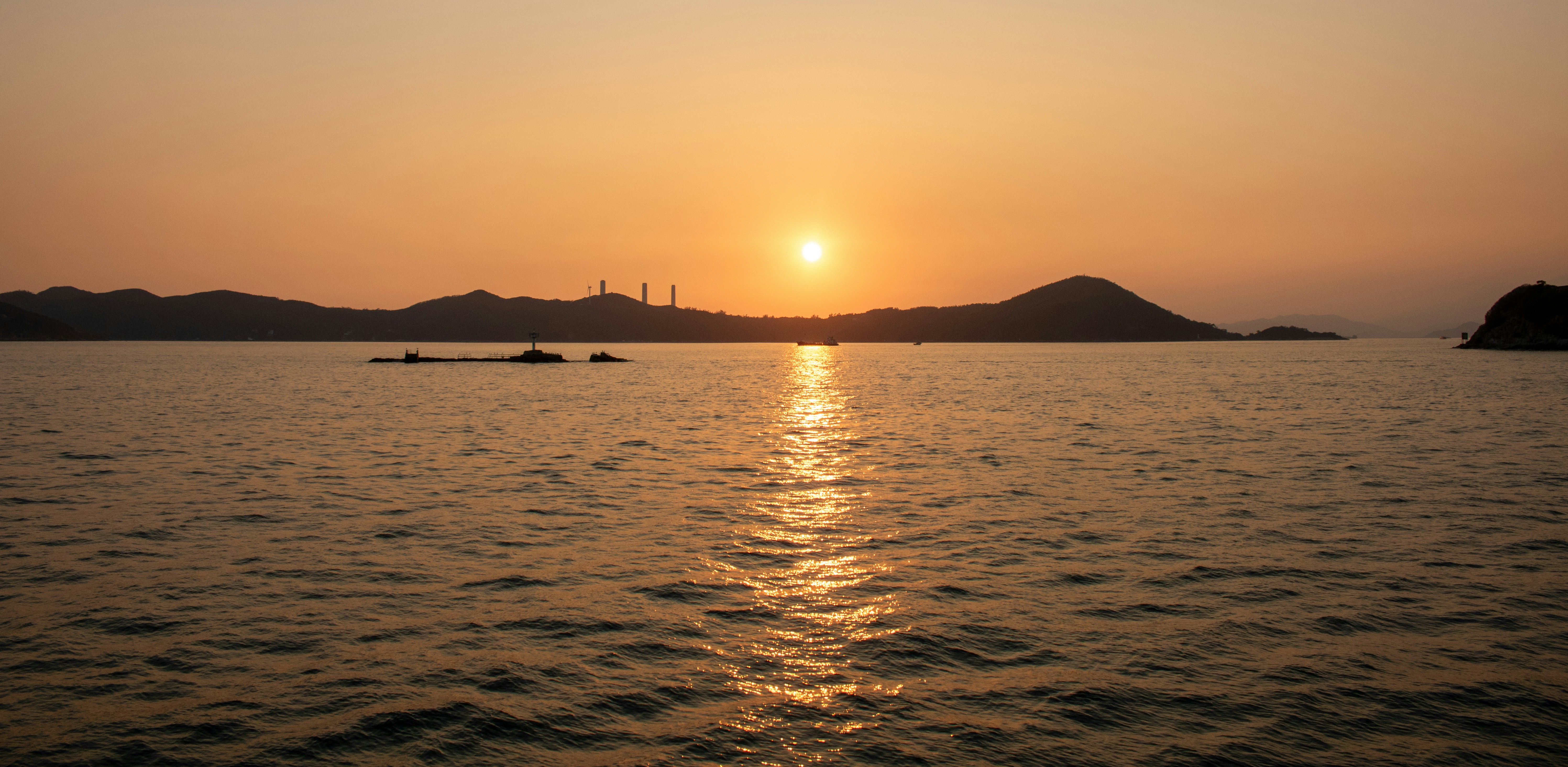 Sunlit Horizon: Boats Drift as the Day Bows to Dusk