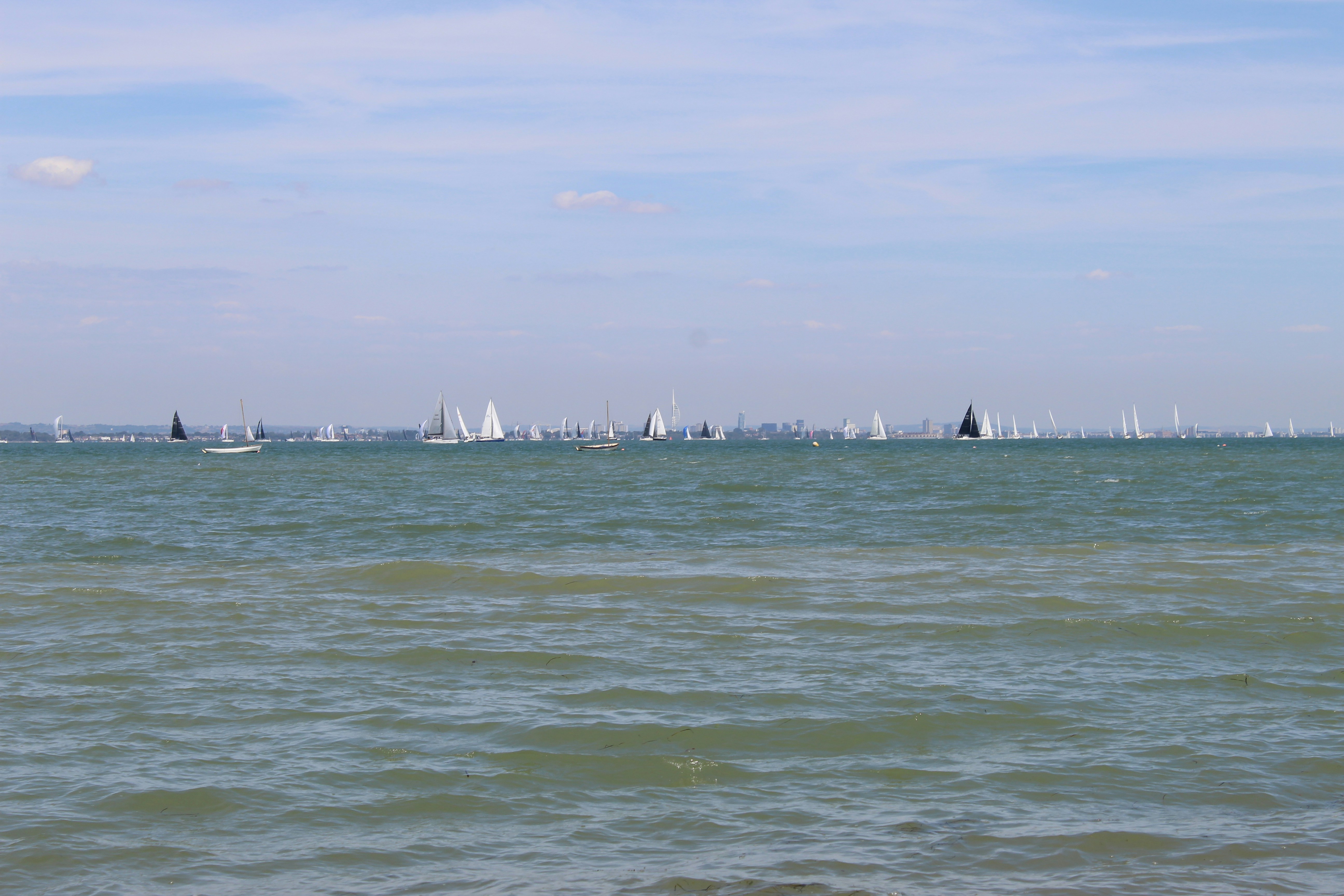 Sailing silhouettes on a calm horizon