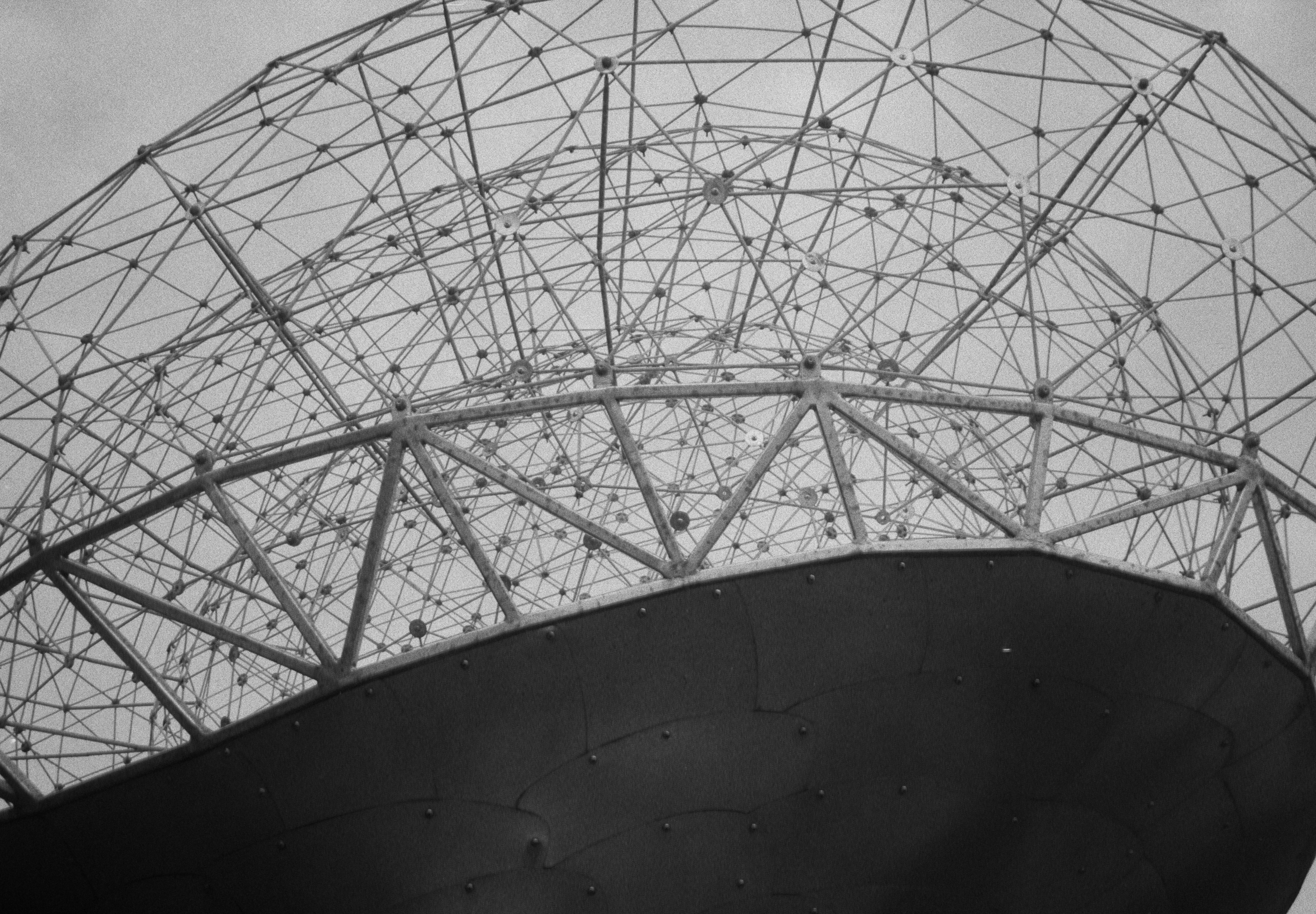 Geometric Dome Overlap: A Close-Up of Steel Lattices Arching Above a Curved Hull
